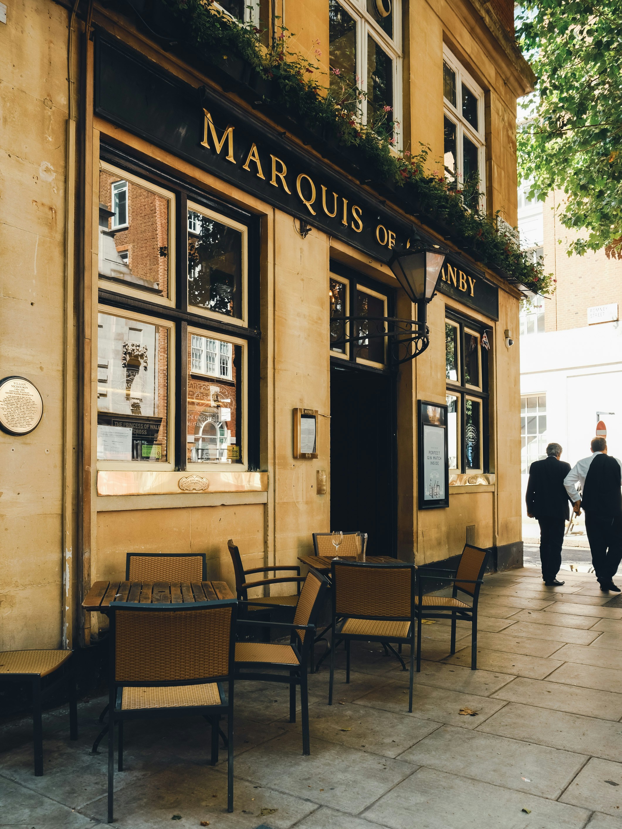 Quelques personnes marchant sur un trottoir à côté d’un bâtiment photo ...