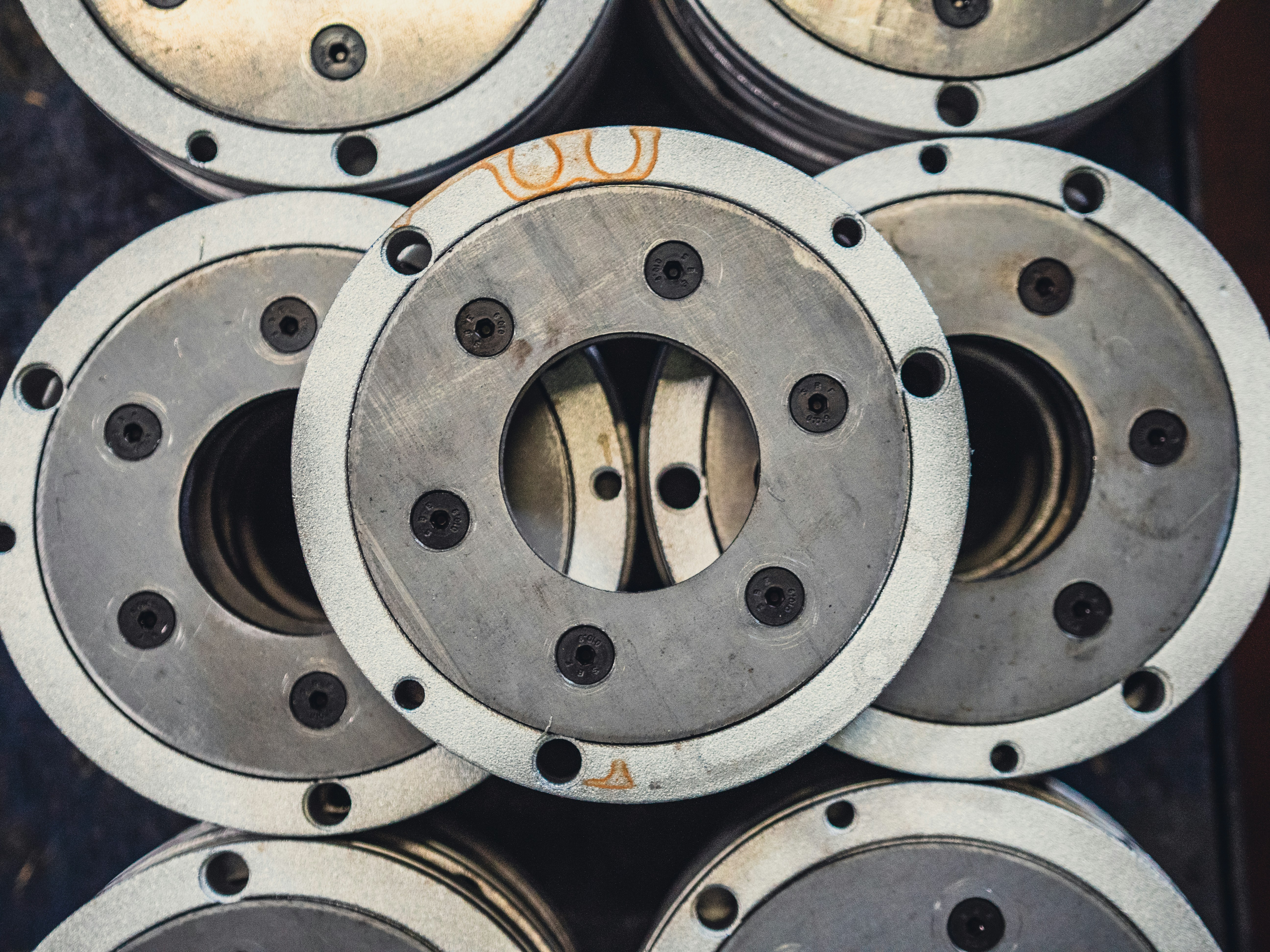 Close-up of stacked metal components showcasing intricate circular designs and fastening details. The arrangement highlights the precision of mechanical engineering.