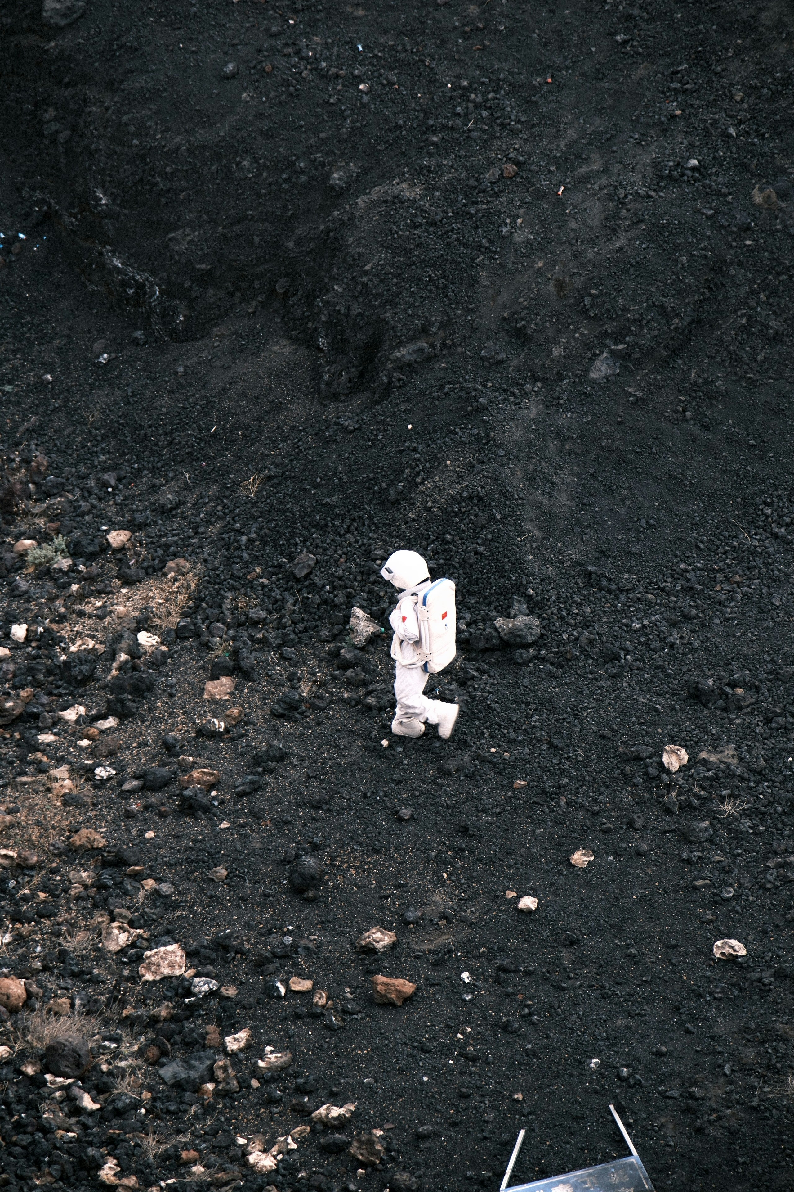 Footsteps on the Charcoal Slope: An Astronaut Traverses a Quiet, Lunar-Volcanic Plain
