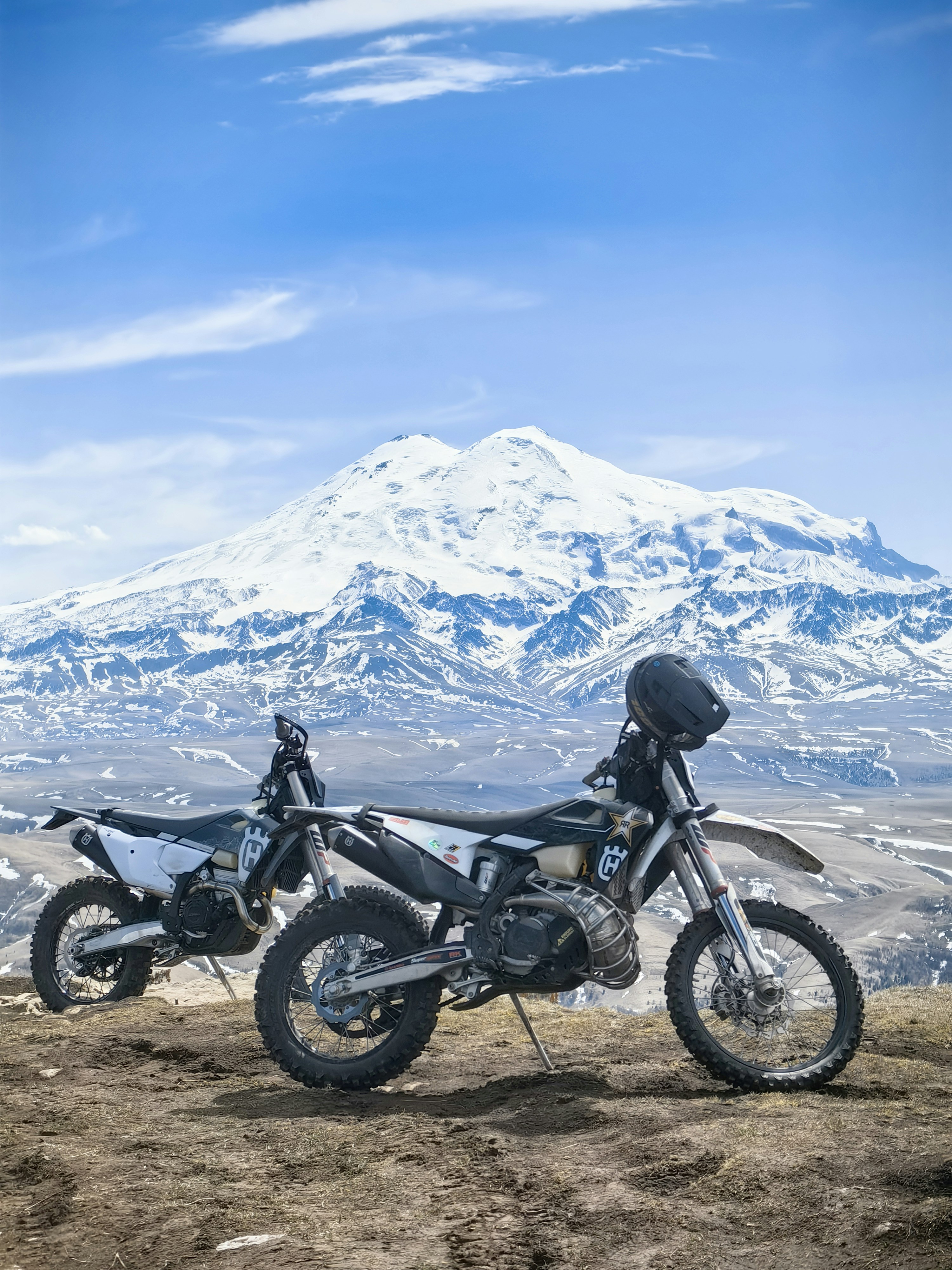 Iron Horses at the Snowline: Dual Dirt Bikes Against a Vast Alpine Backdrop