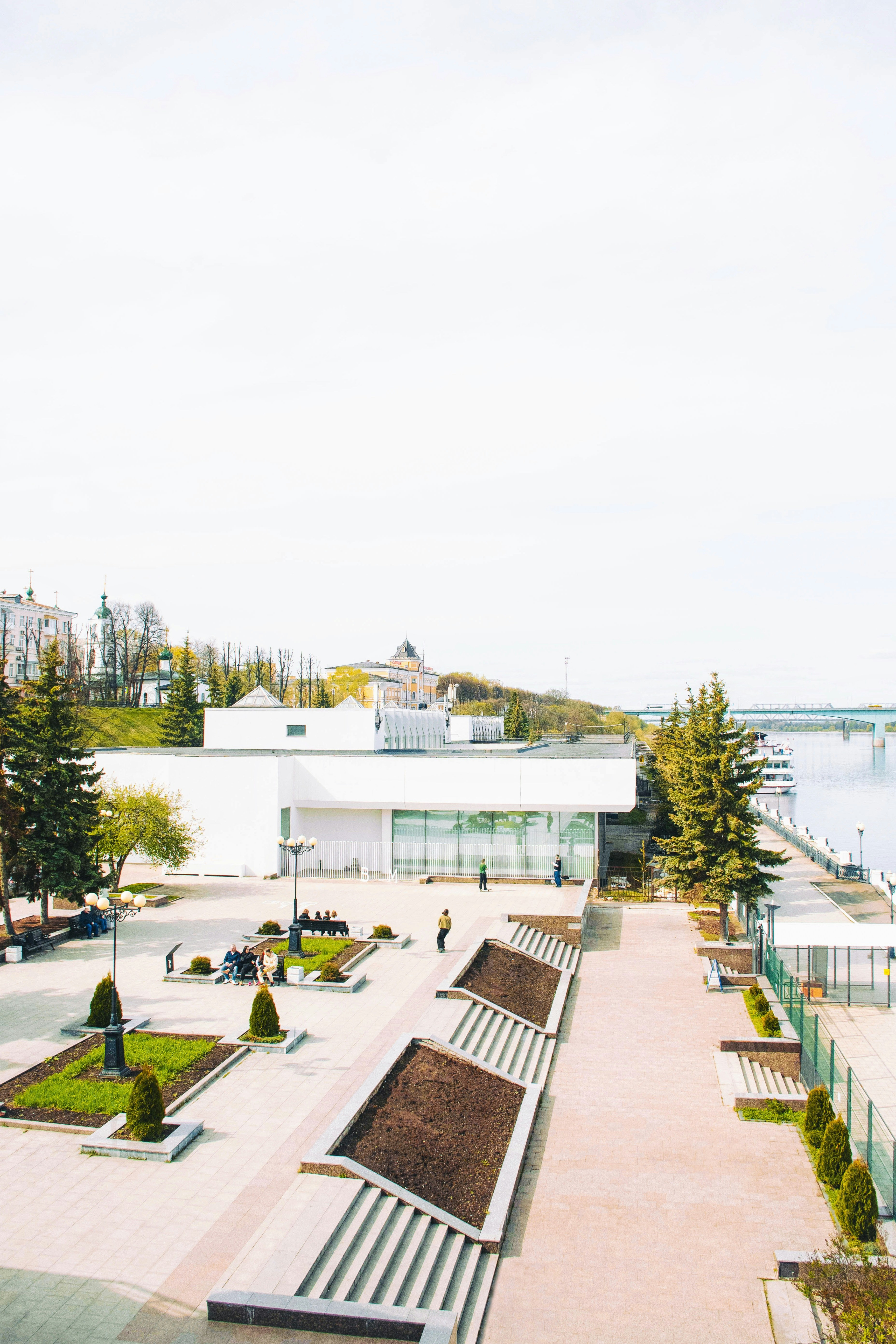 Sunlit Harbor Promenade: Geometric Planters, White Pavilion, and Quiet Water
