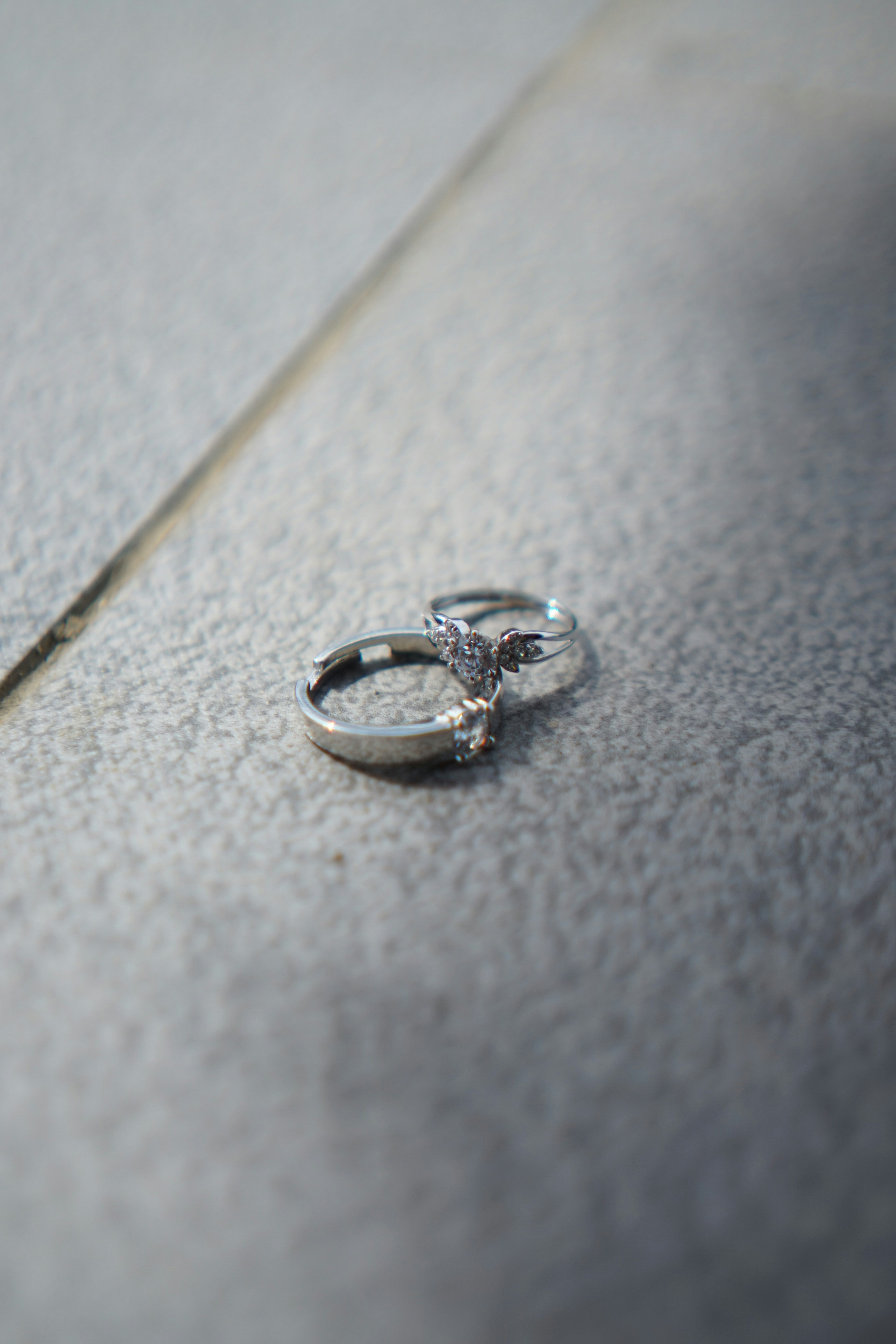 Two intertwined wedding rings resting on a textured surface, symbolizing unity and commitment.
