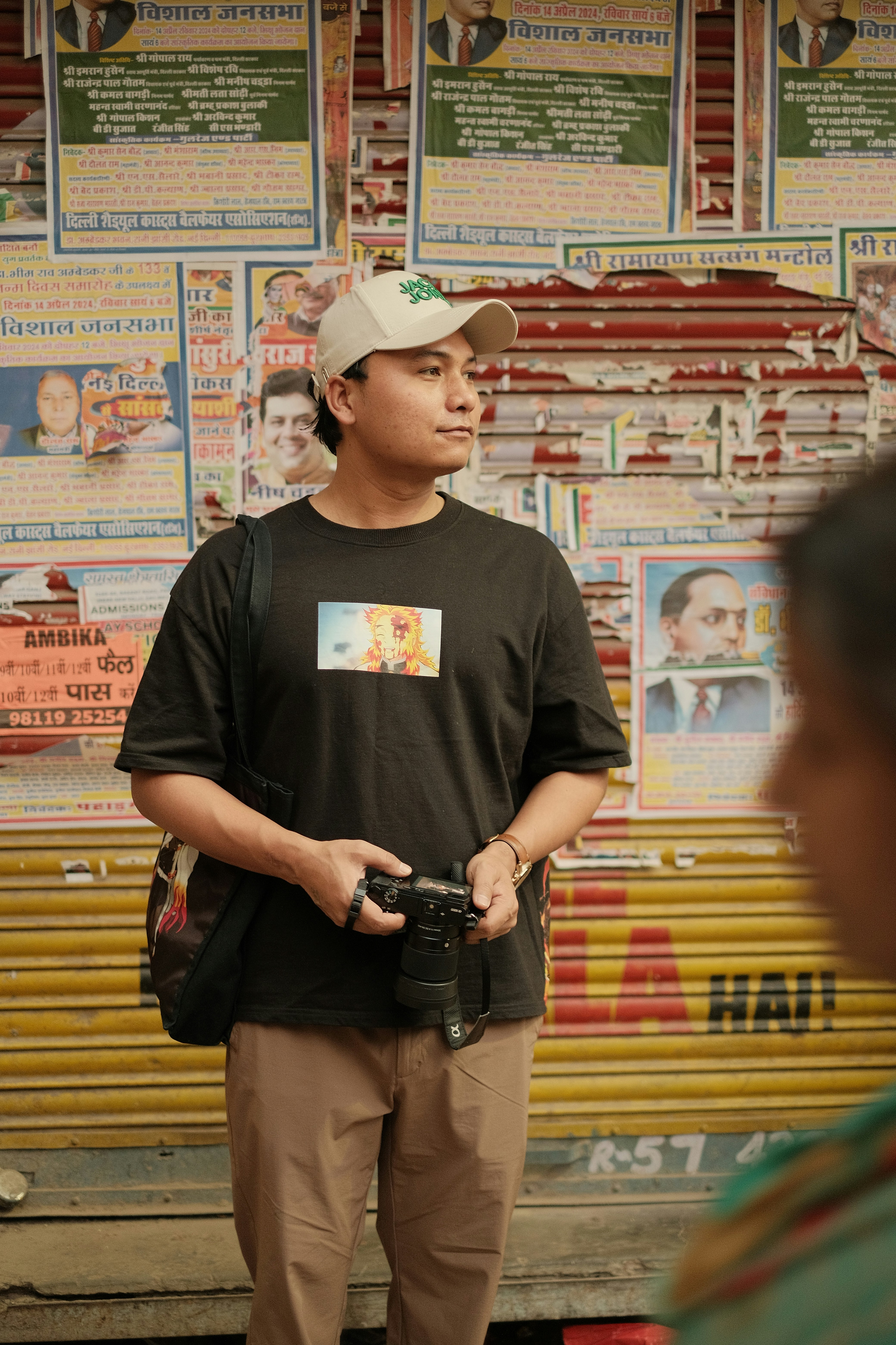 A man standing in front of a wall with posters on it photo – Free India ...