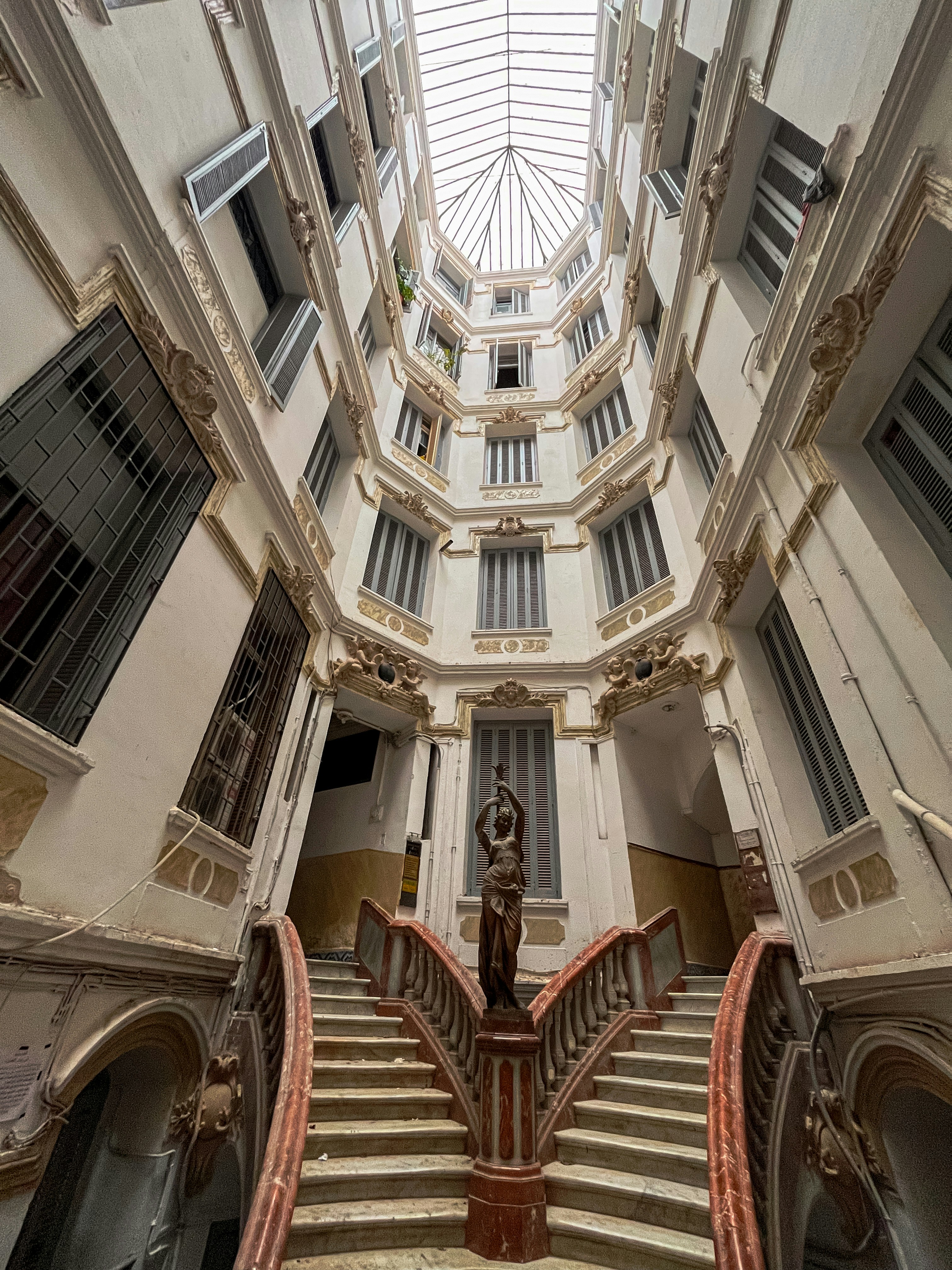 Statue at the Spiral Staircase in a Sunlit Atrium