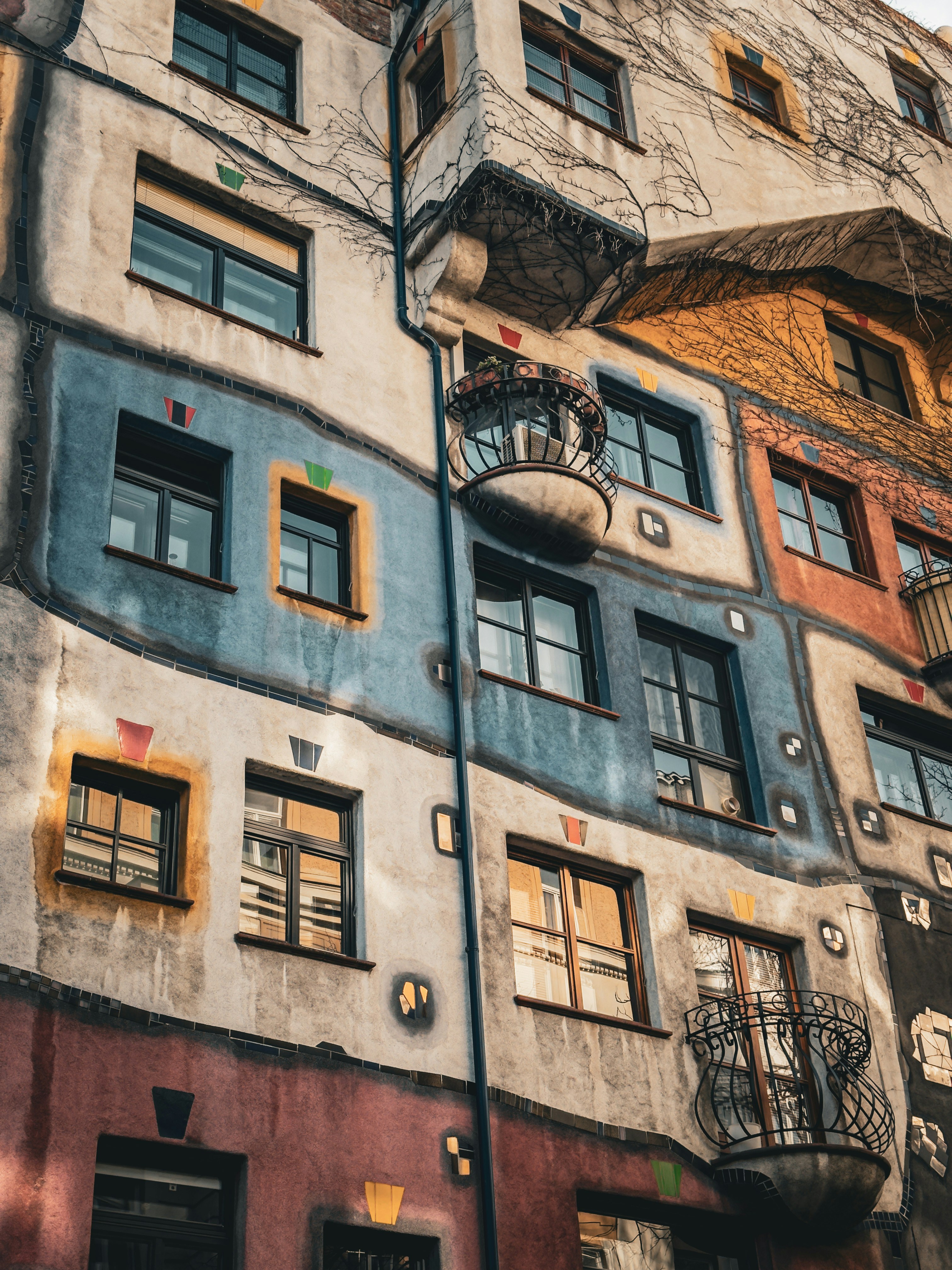 Kaleidoscopic Facade: Multicolor Windows and a Curved Balcony