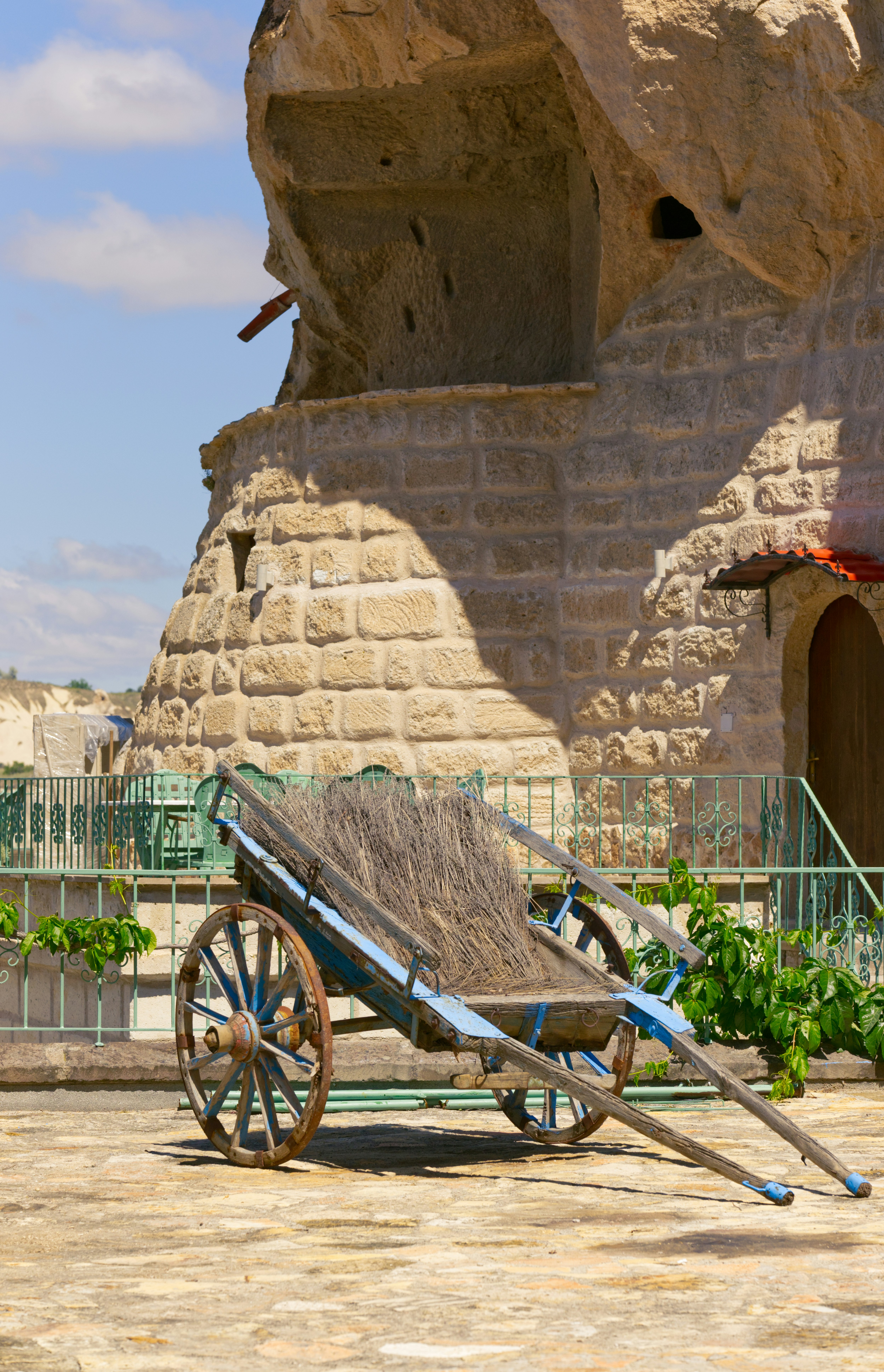 Blue-Wheeled Hay Wagon at the Foot of a Timeworn Stone Facade