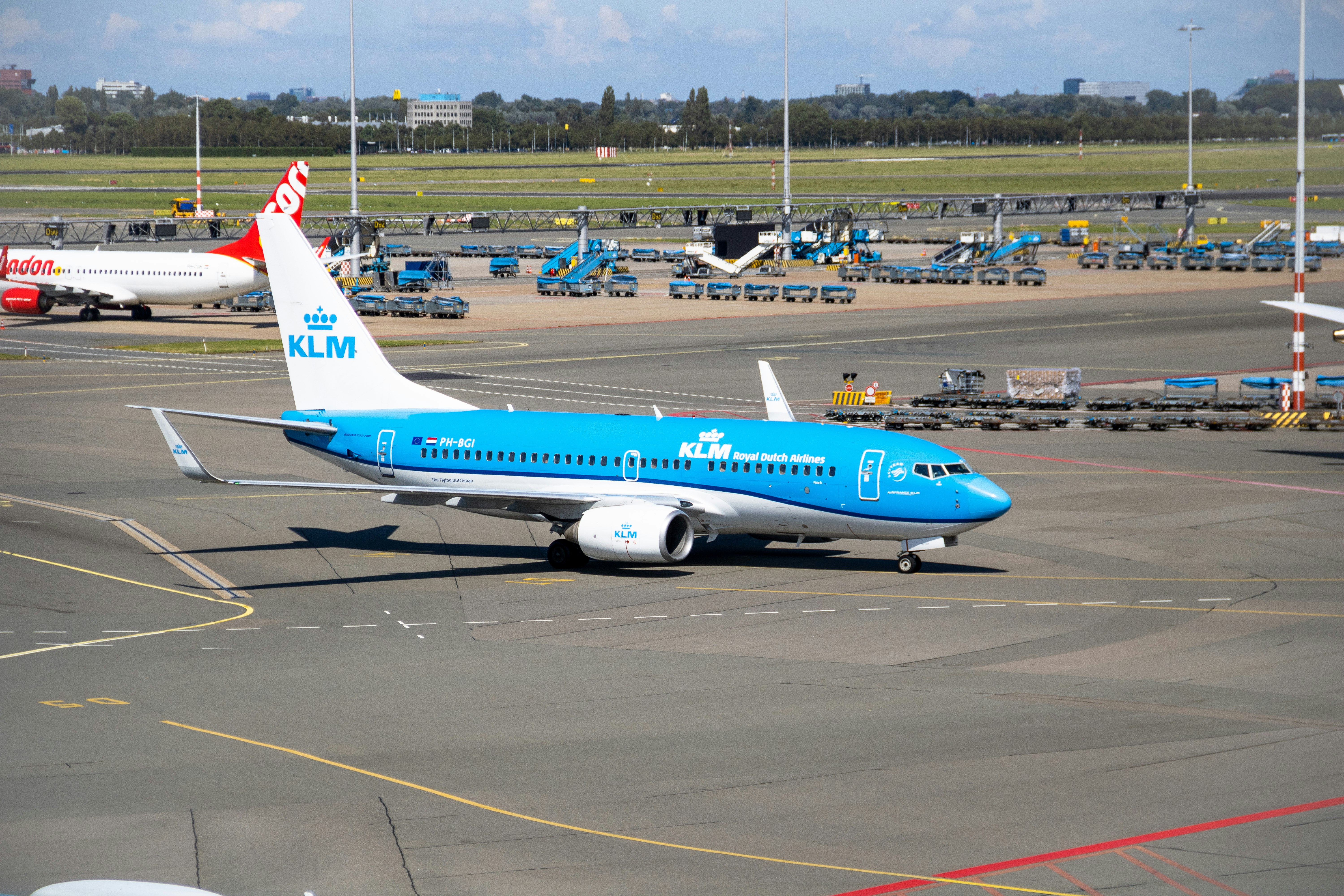 A blue and white plane is on the runway photo – Free Amsterdam Image on ...