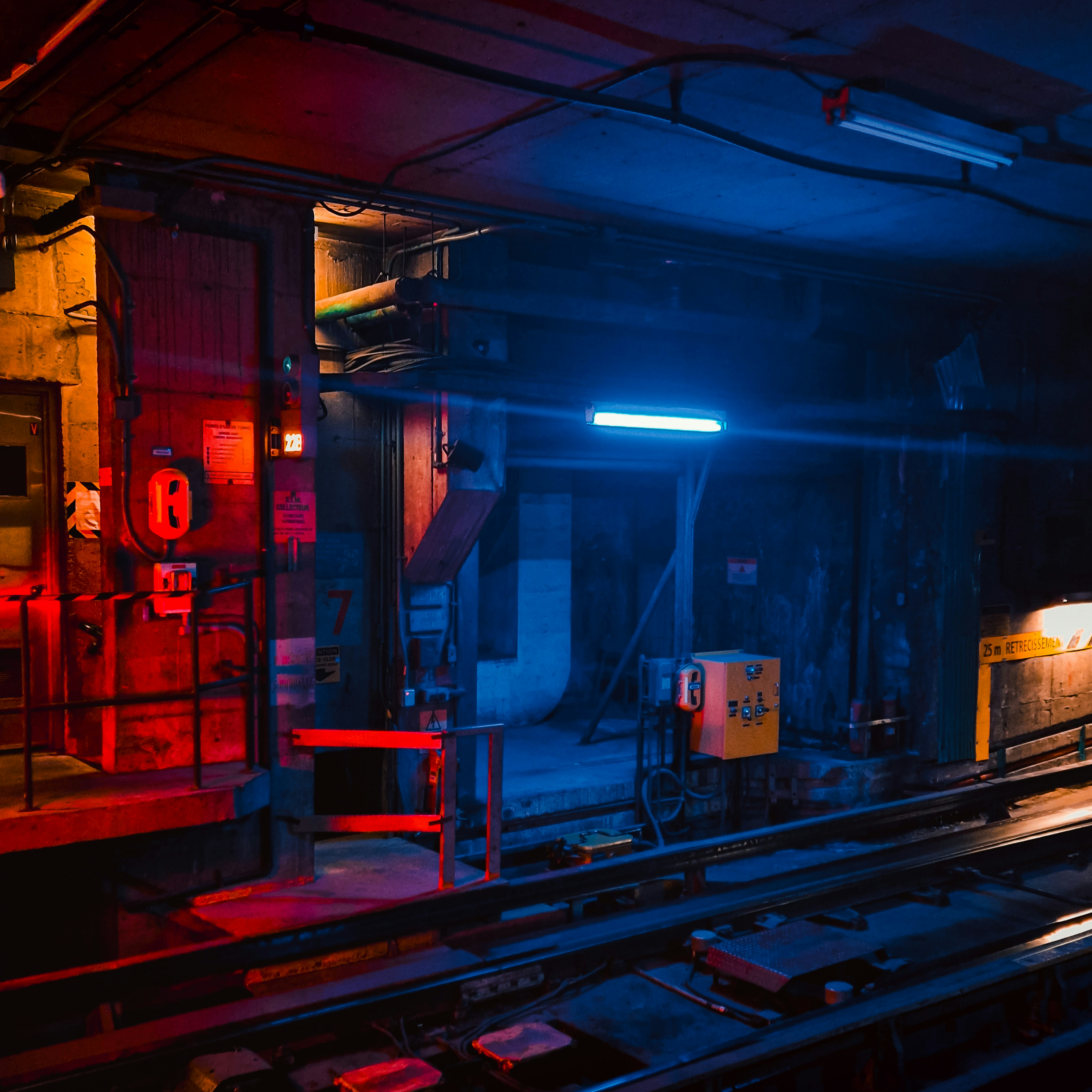 Cobalt Neon Over Rails: Night in an Industrial Corridor