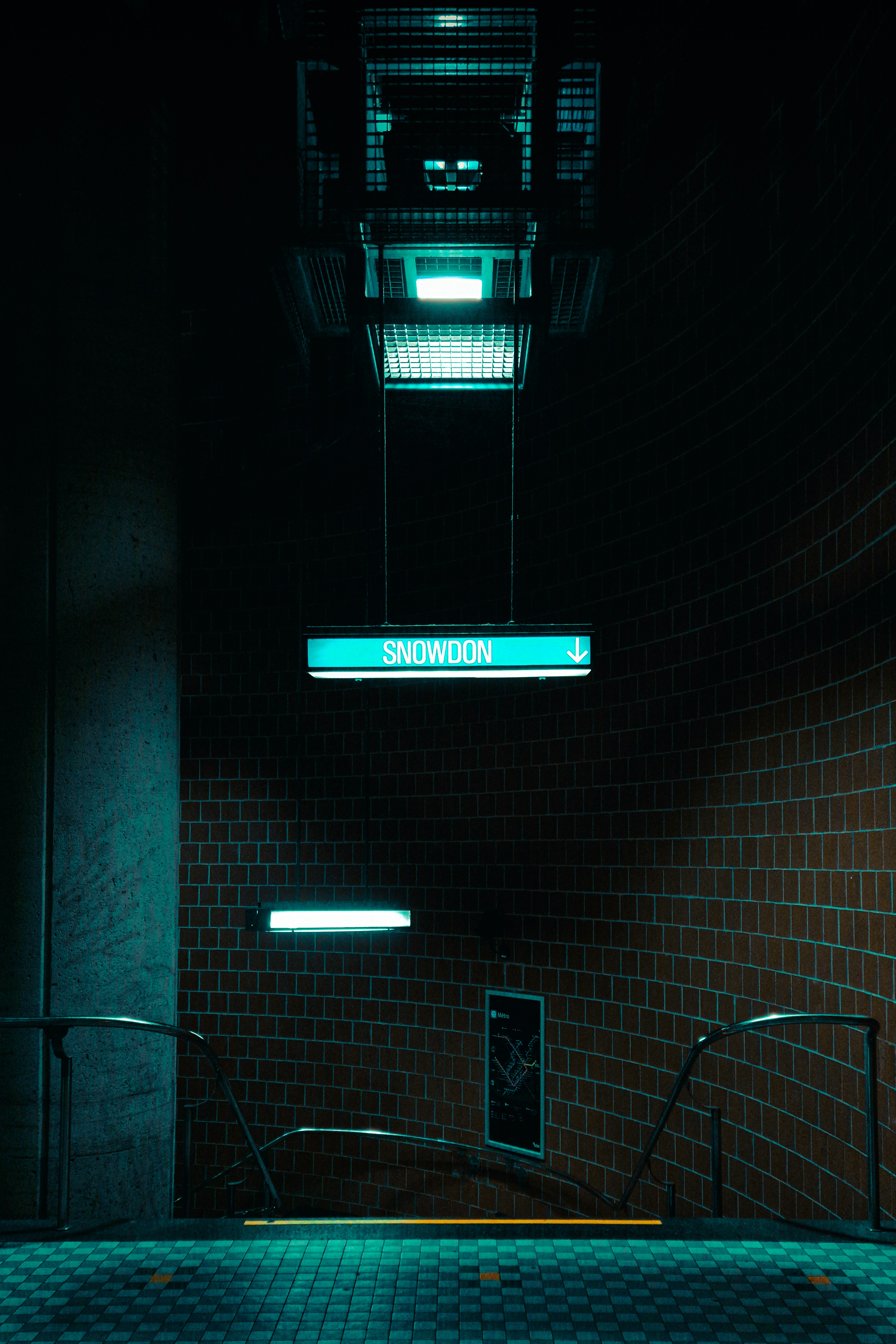 Snowdon Sign in a Teal-Illuminated Underground Stairwell