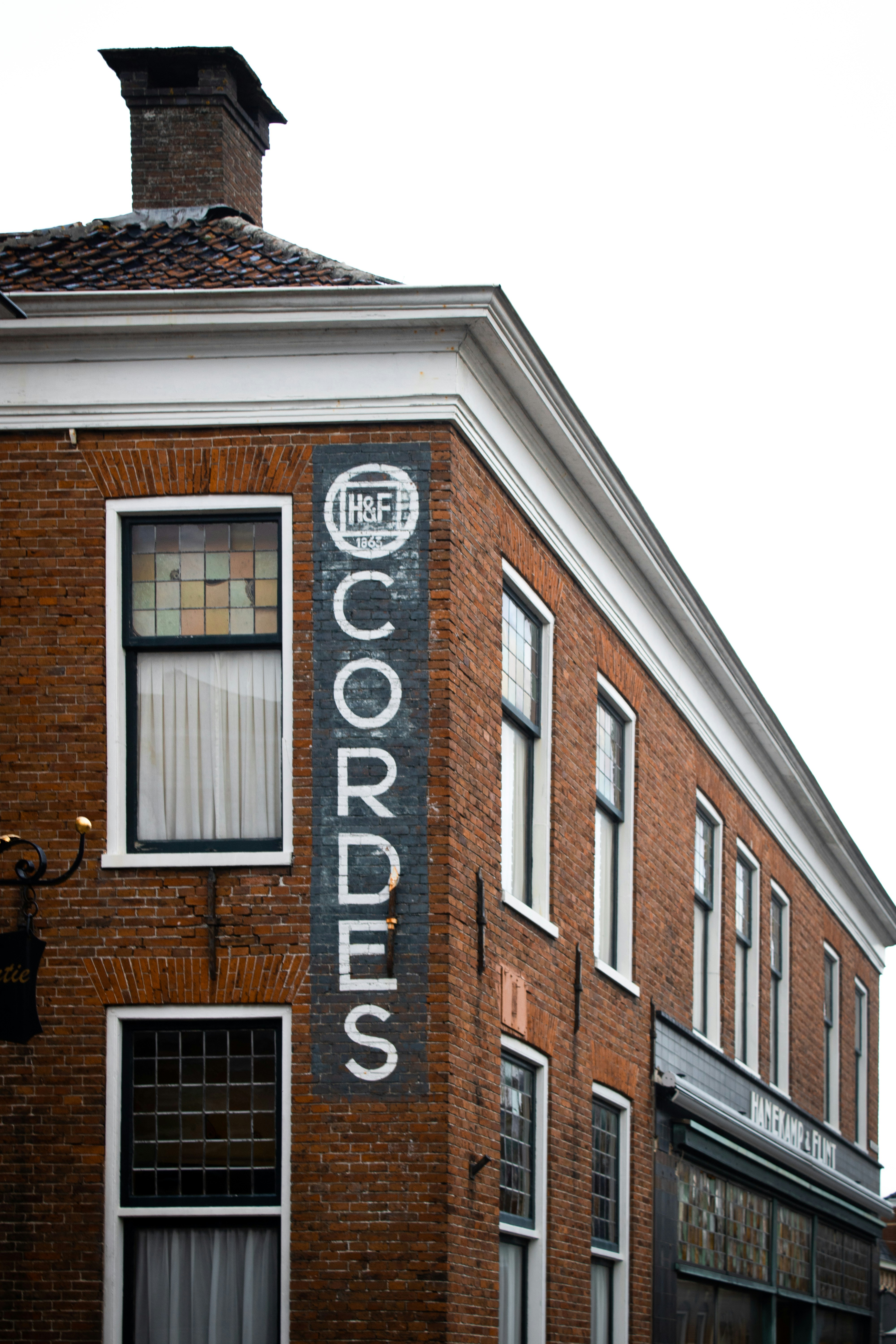 A brick building with a sign on the side of it photo – Free Groningen ...