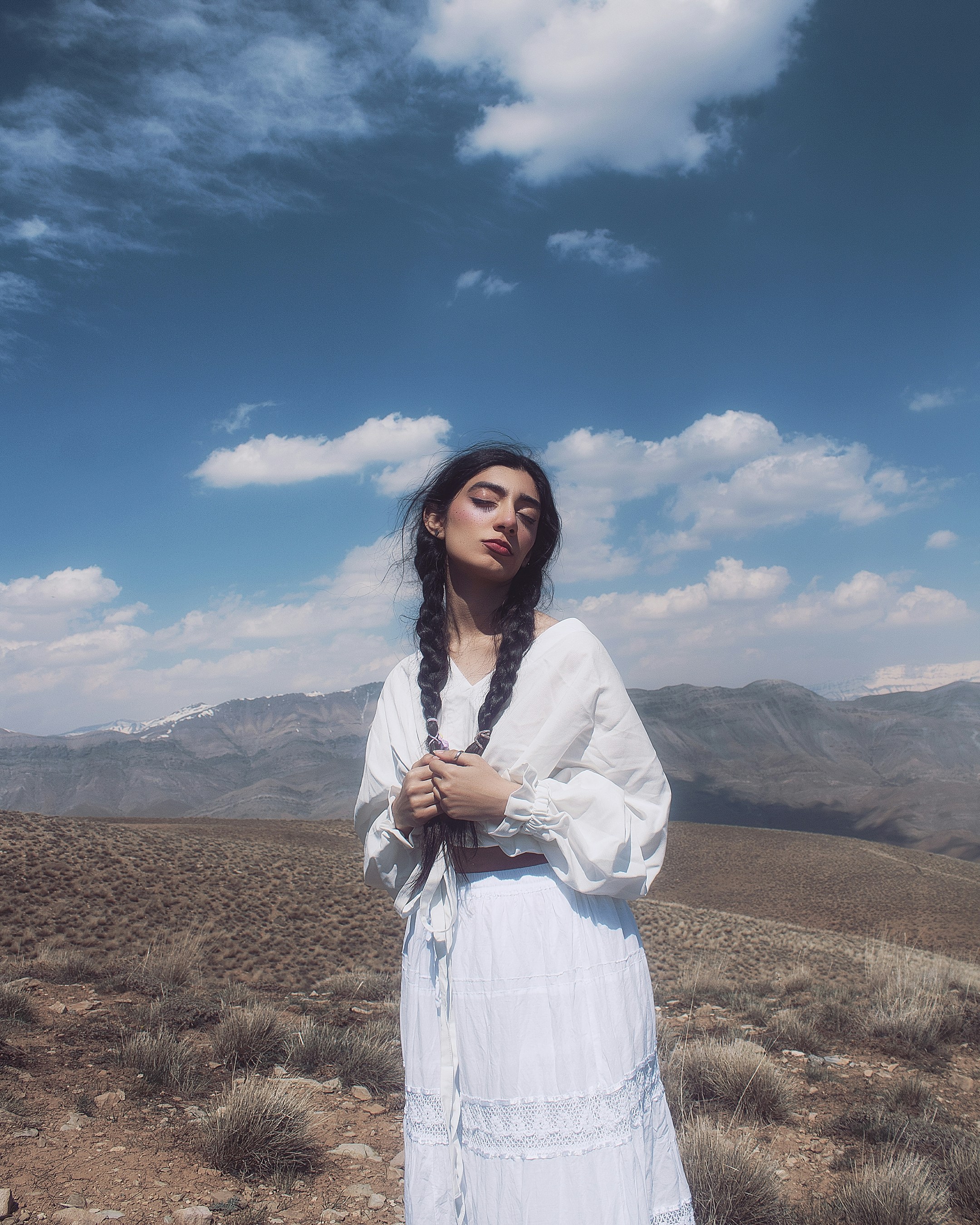 Desert Reverie: White Dress Portrait Beneath a Cloud-Swept Sky