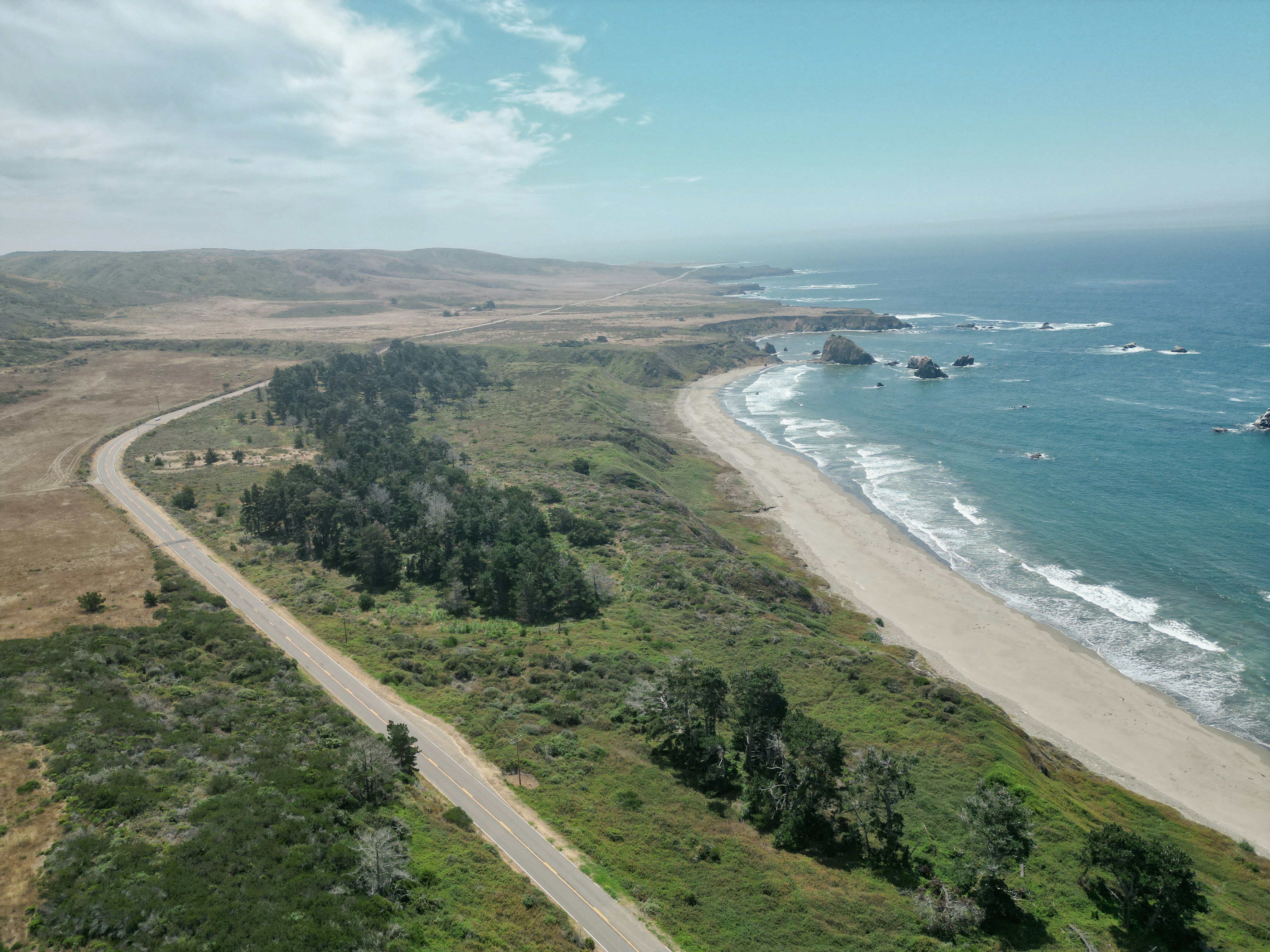 An aerial view of a road near the ocean photo – Free Beach Image on ...