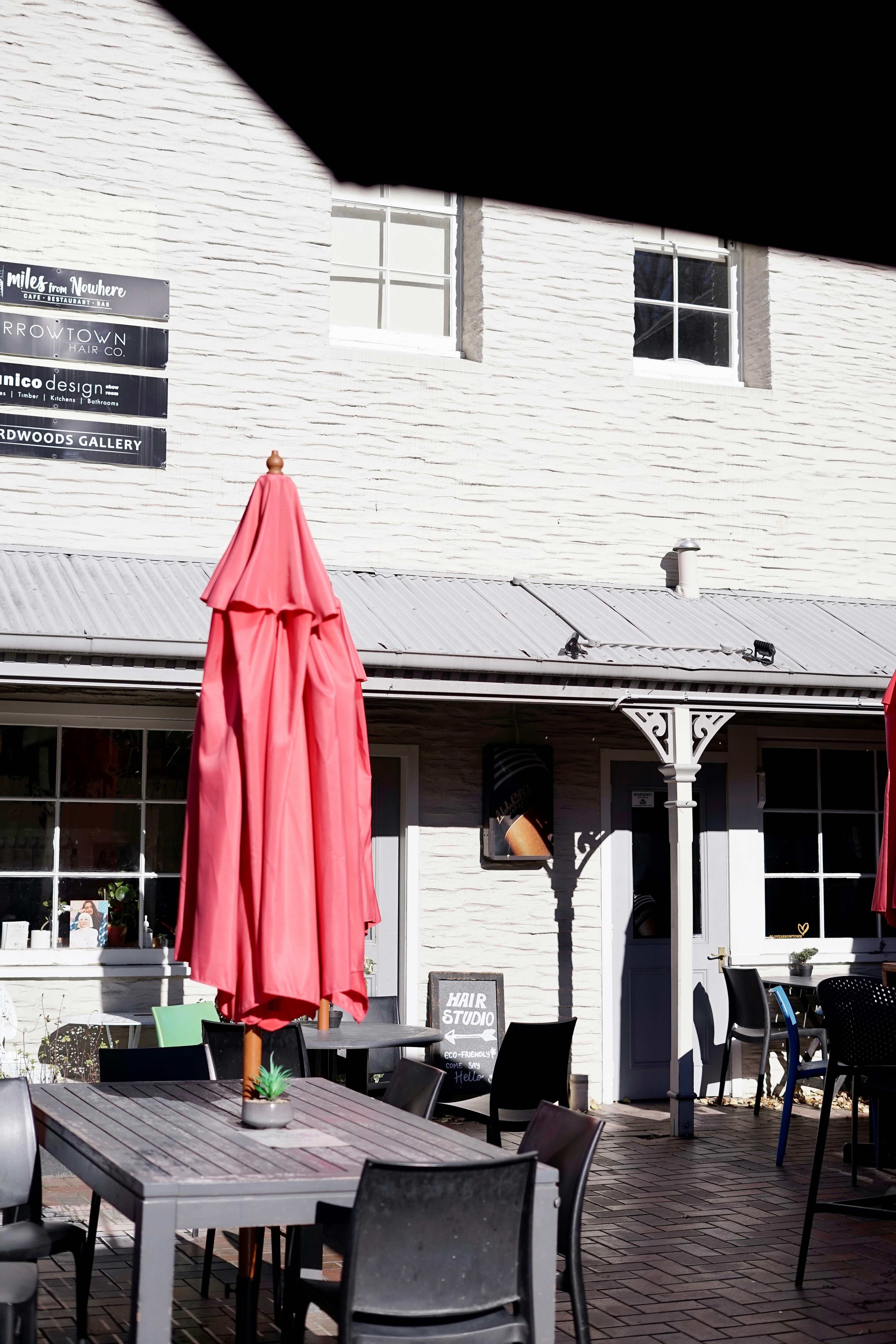 Coral Umbrella Centerpiece Over a Sunlit Café Patio