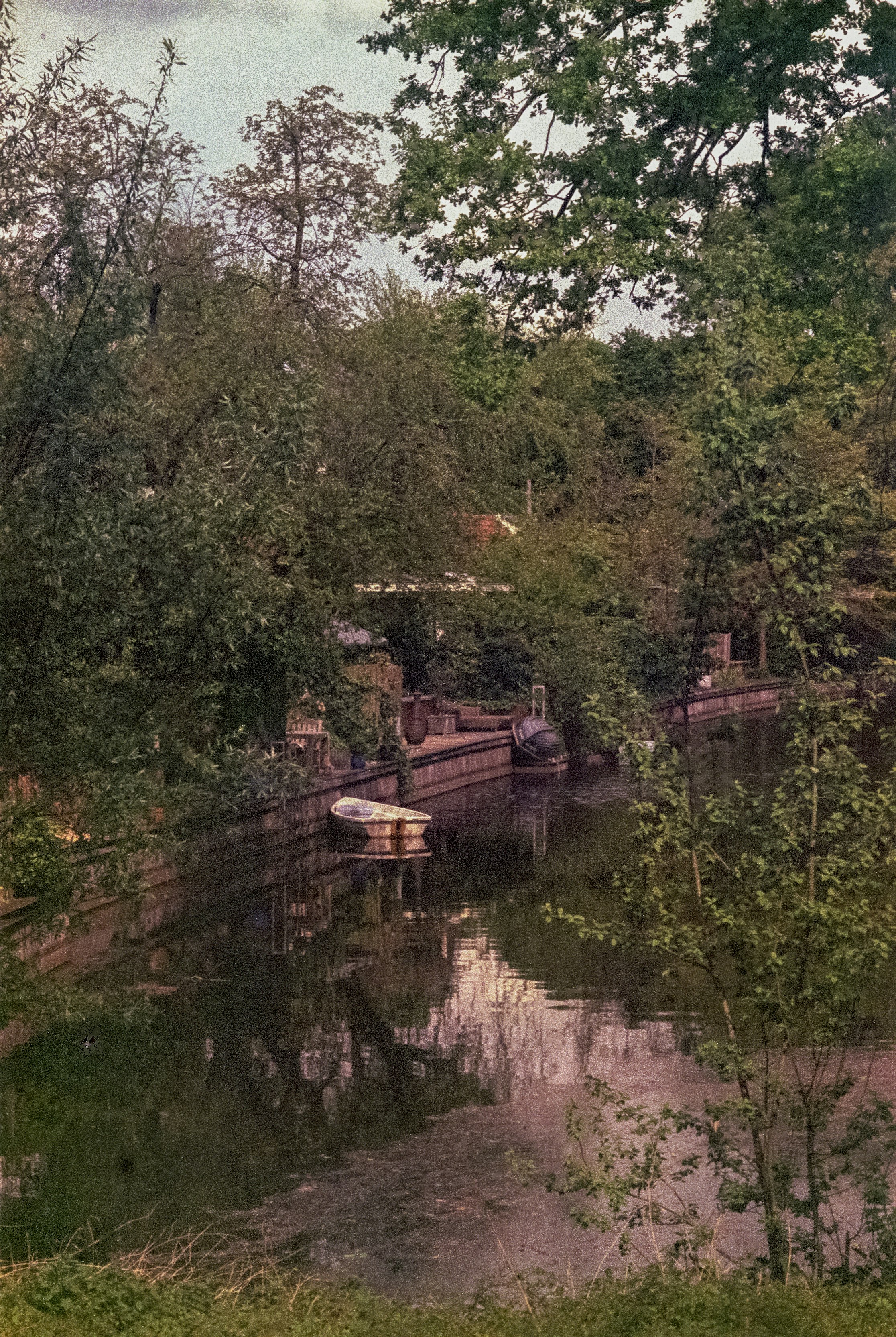 Verdant Canal Quiet: Boats and Reflections Under a Leafy Canopy