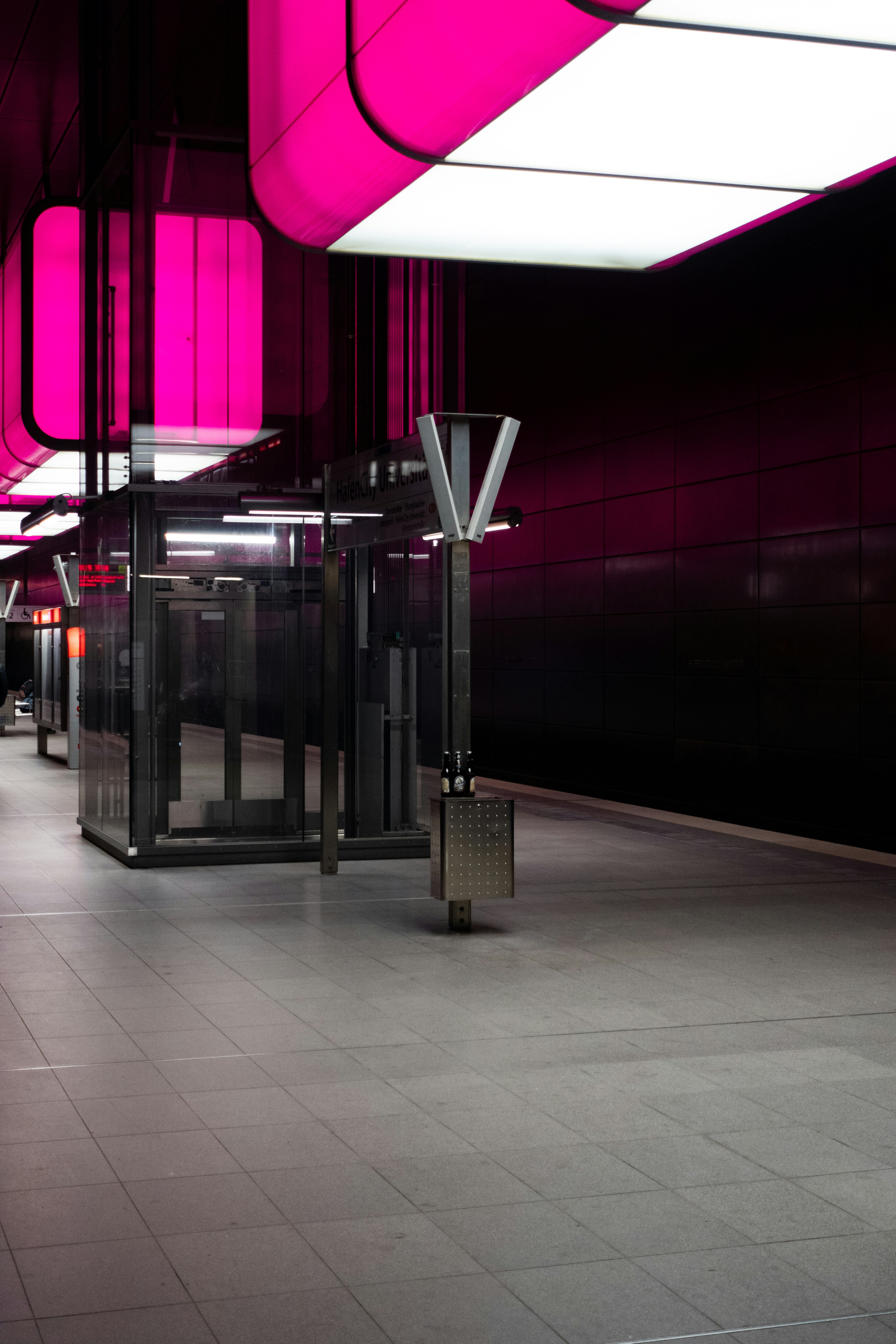 V-Shaped Beacon Beneath Magenta Neon in a Quiet Subway Platform