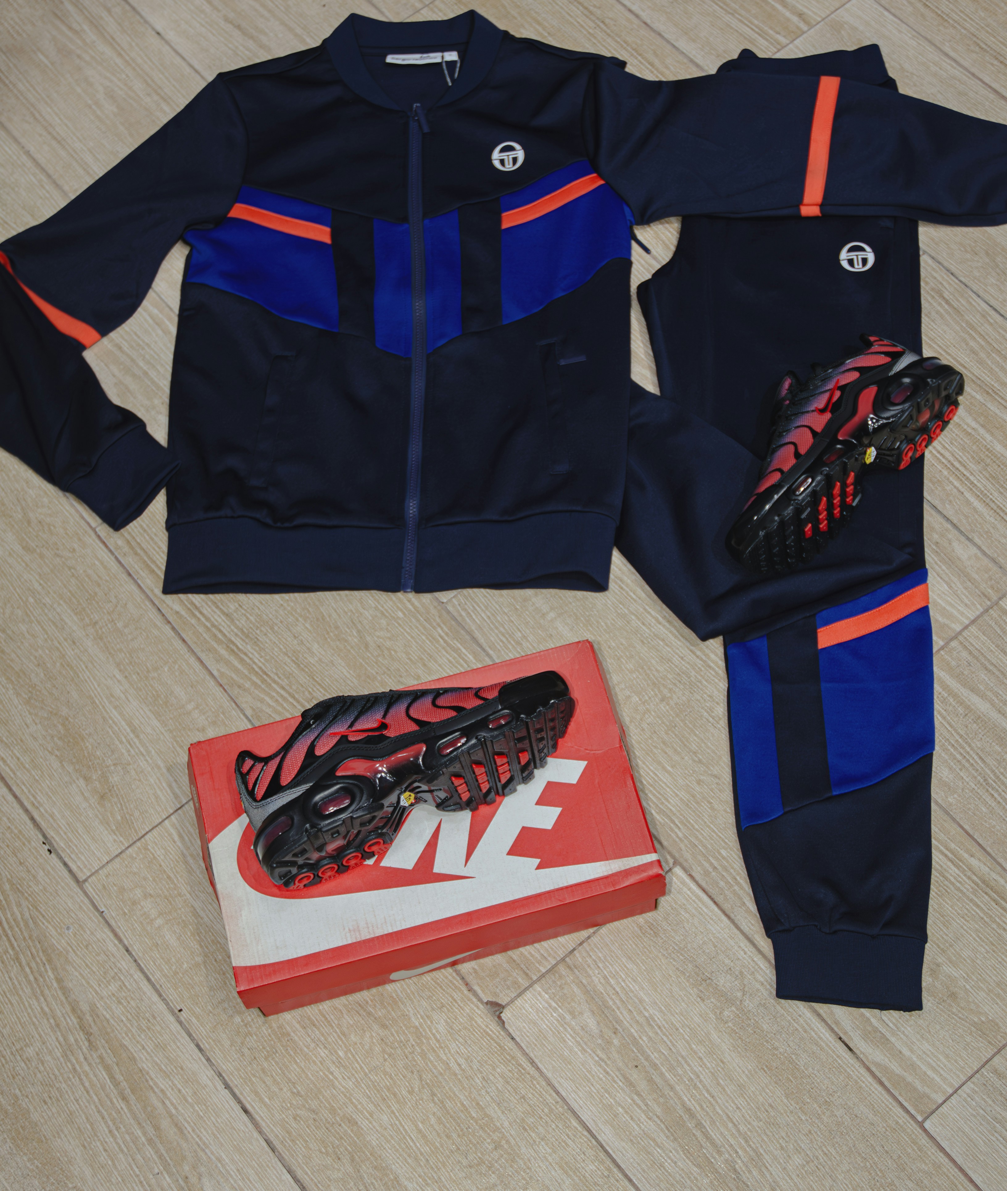 A pair of shoes and a pair of running shoes sit on the floor next to ...