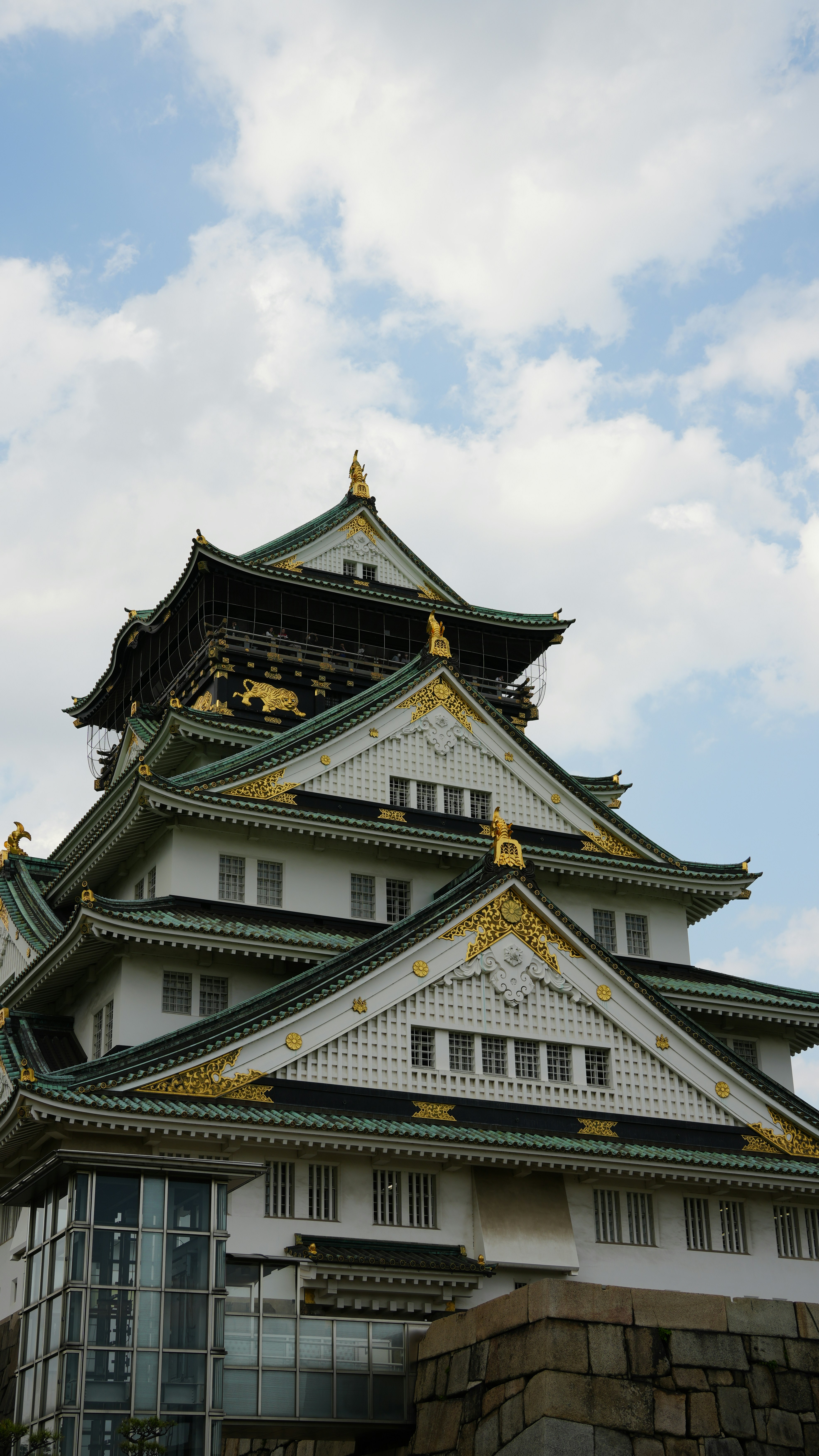 A tall white and gold building under a cloudy sky photo – Free Osaka ...