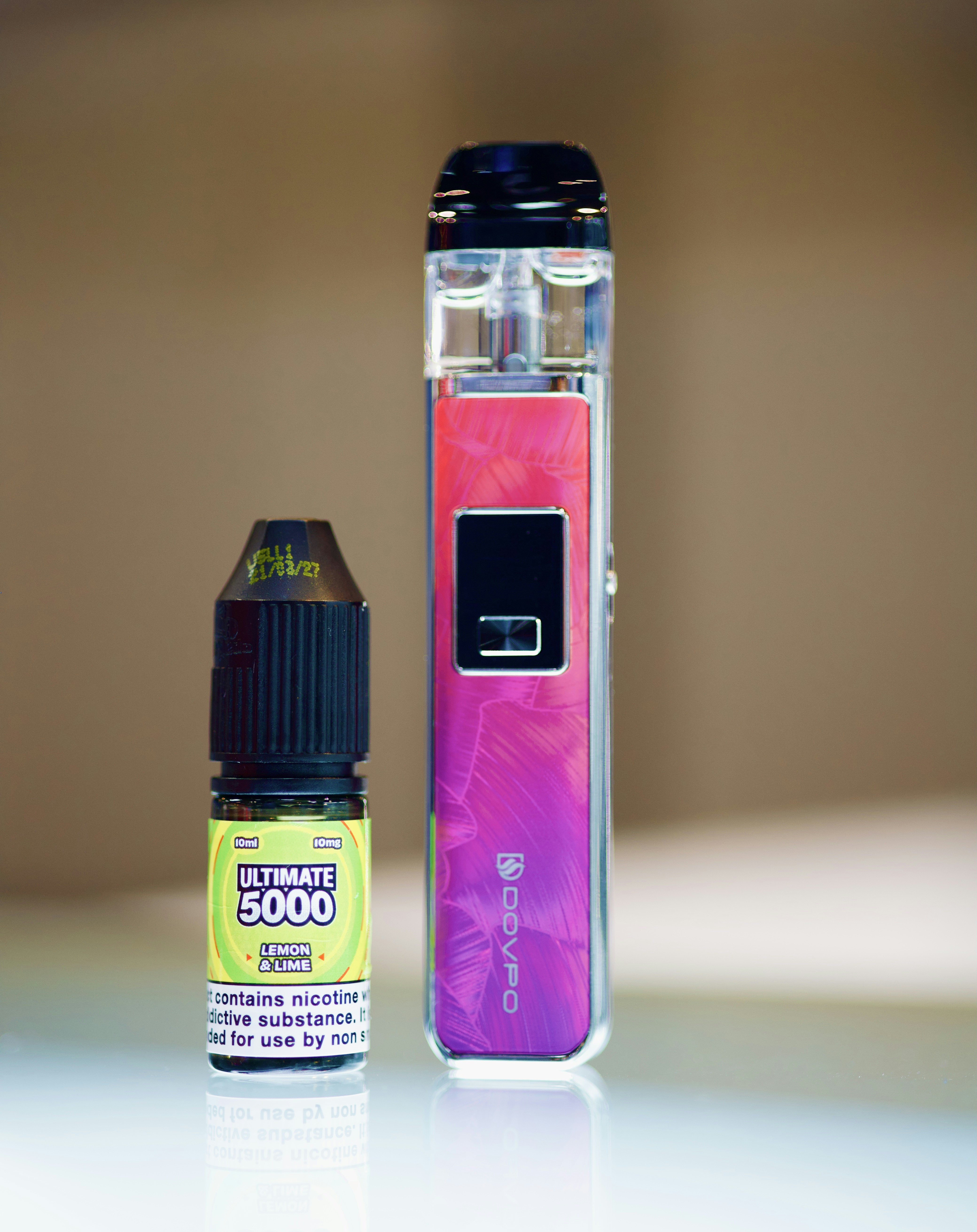 A bottle of e - liquid next to an electronic device photo – Free Nec ...