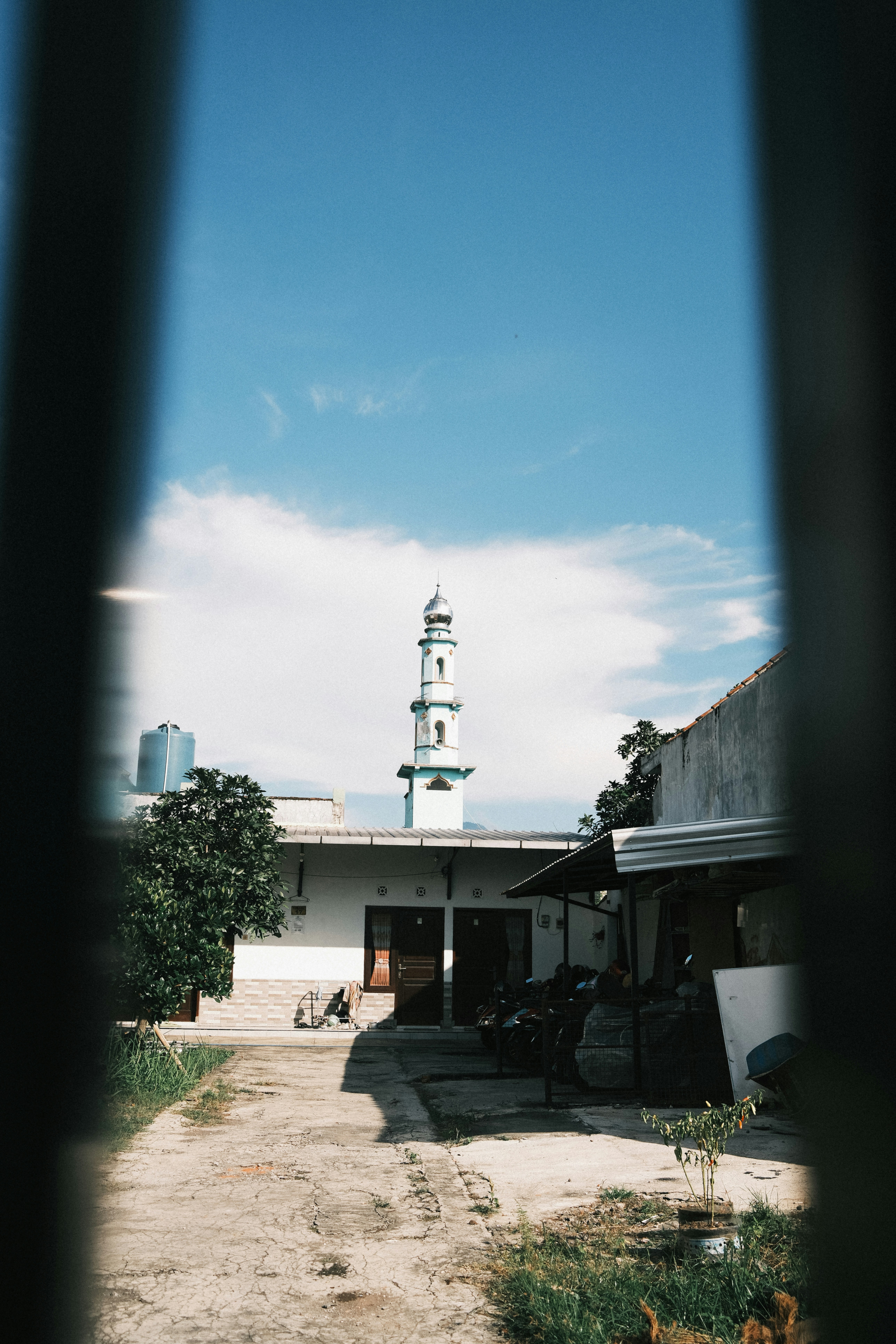 Minaret in Focus: A Quiet Courtyard Portrait Framed by a Narrow Gap