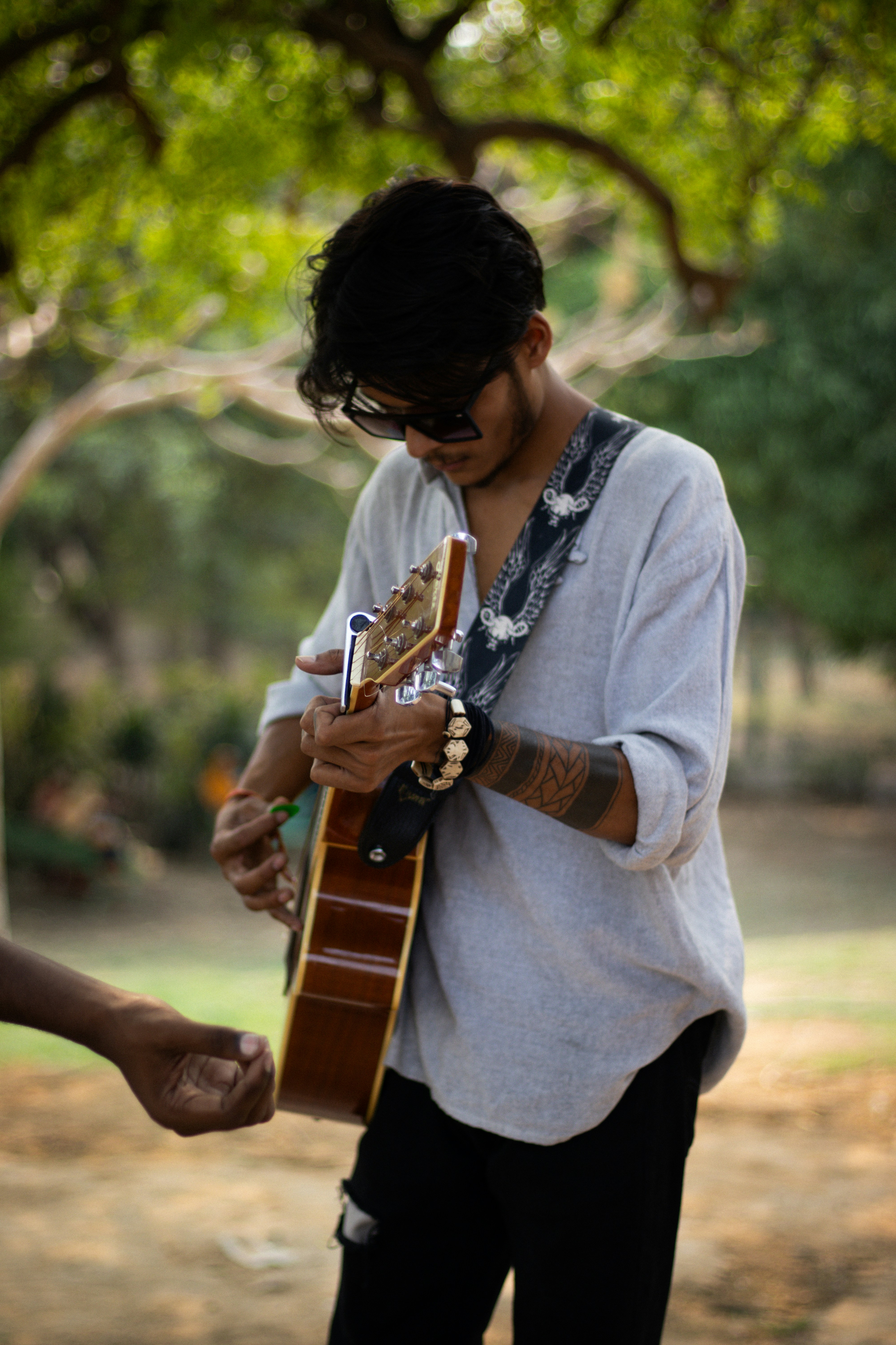 Muted Sun, Bold Fingers: A Park Guitarist in Dappled Light