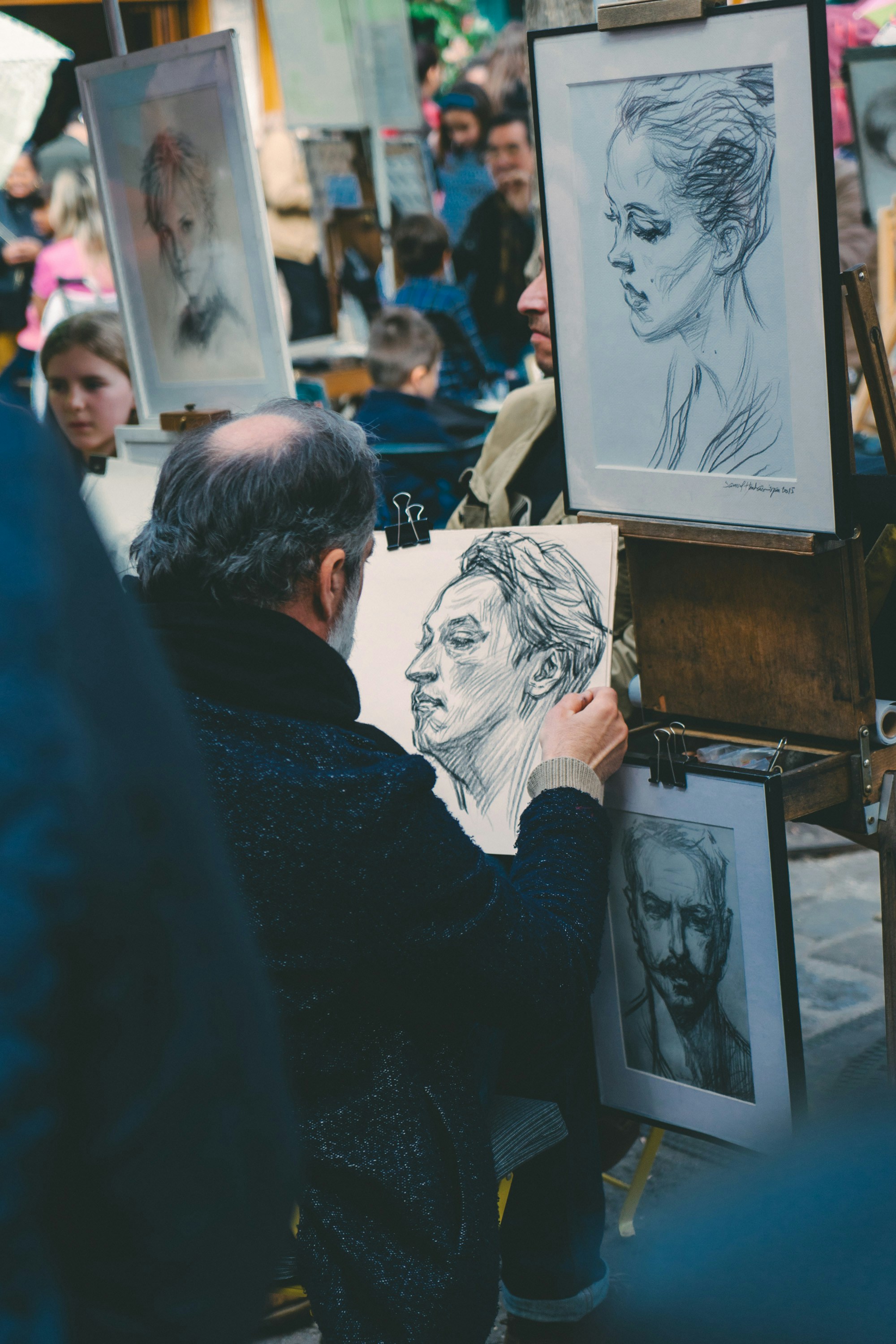 A man is drawing a picture on a easel photo – Free Paris Image on Unsplash