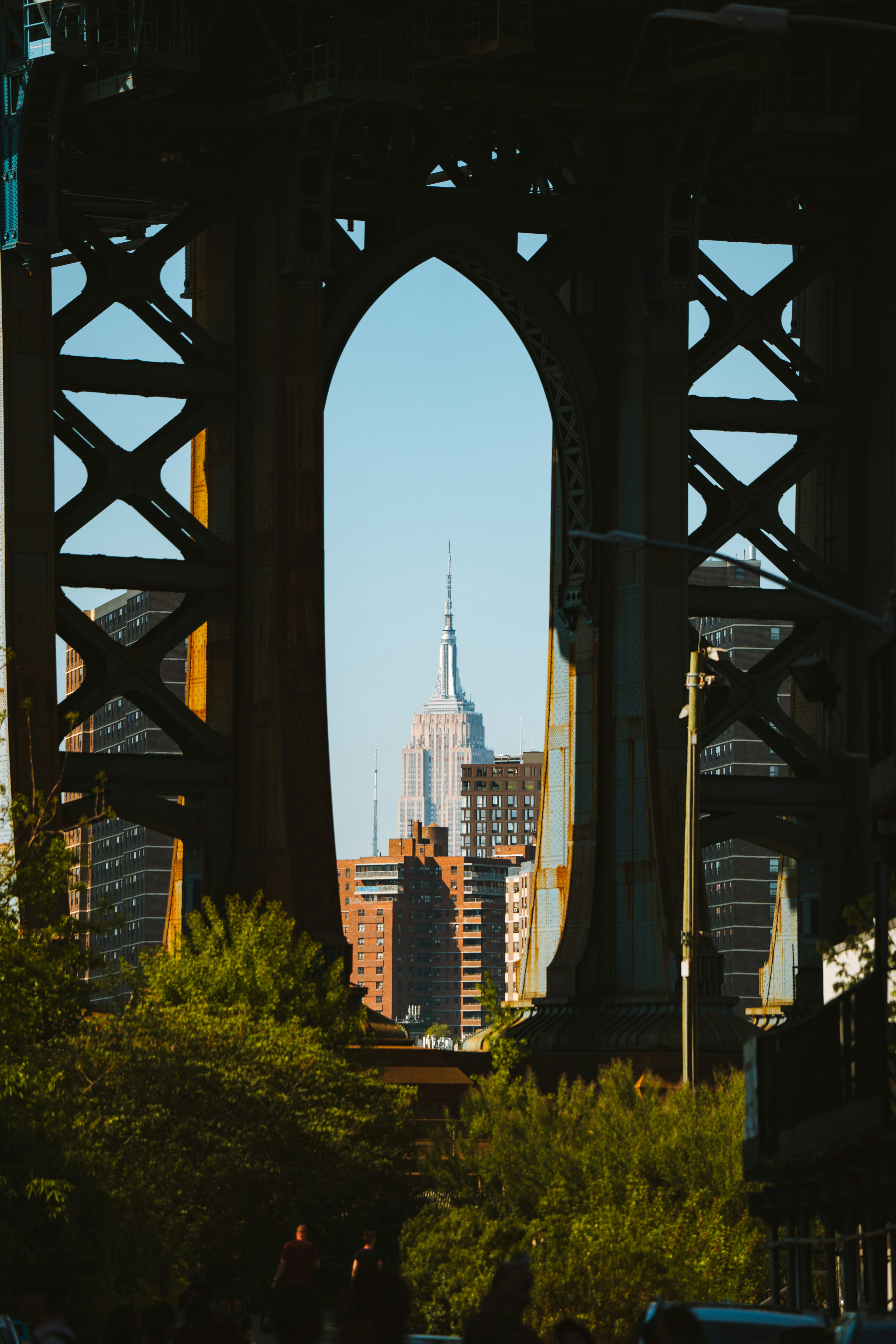 Archway to Midtown: Empire State Framed by a Bridge's Steel Lattice