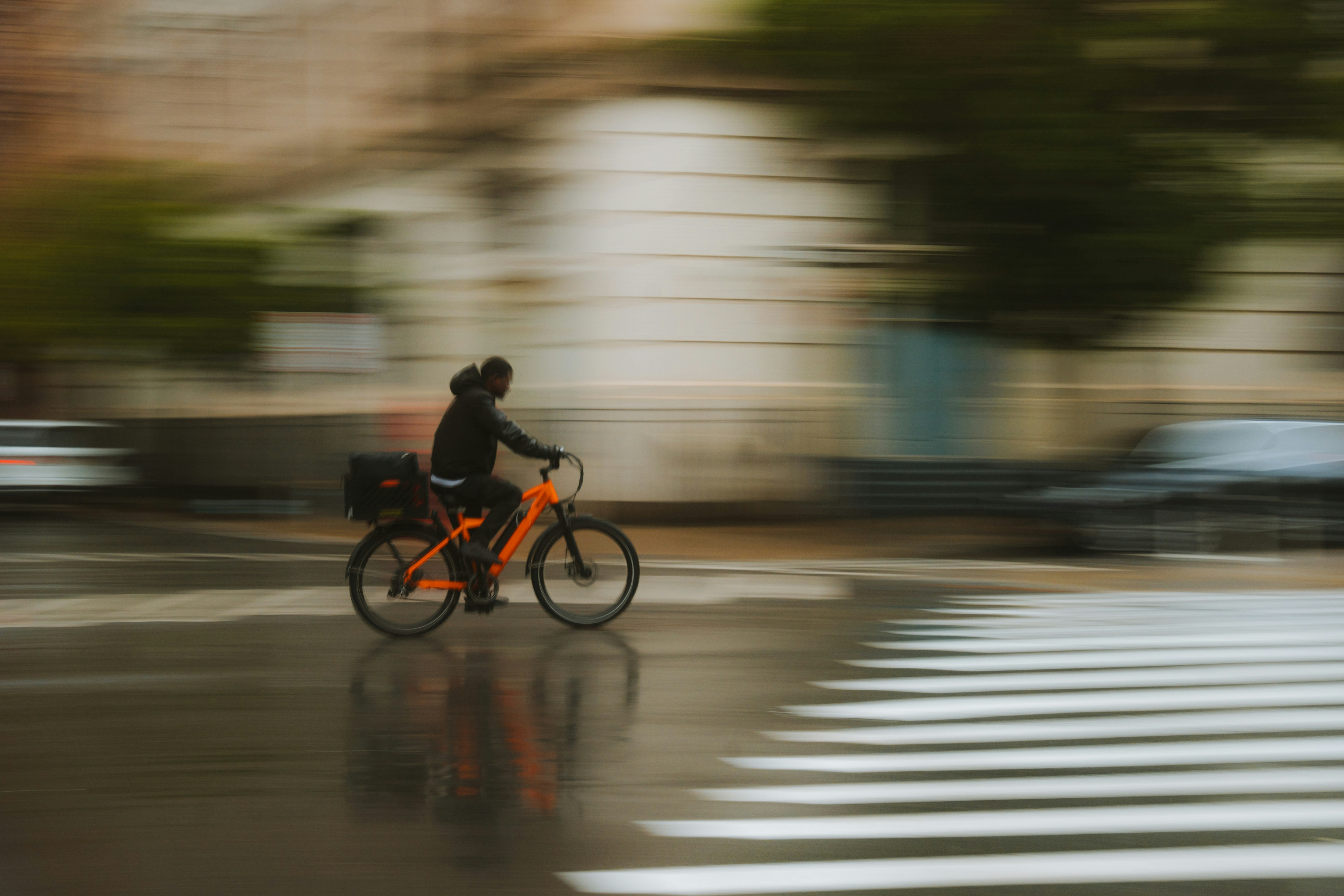 A person riding a bike on a city street photo – Free Street photography ...
