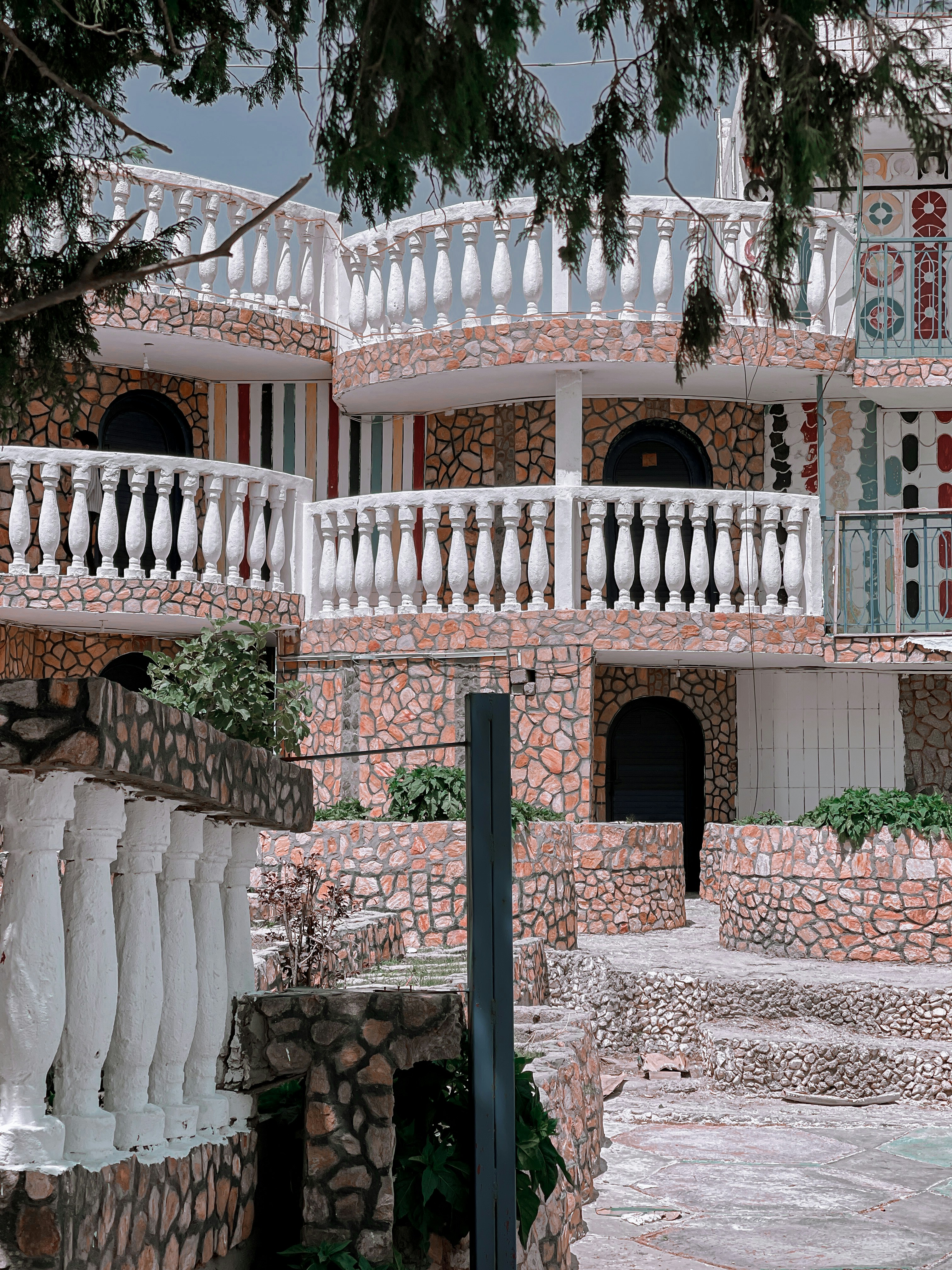 Courtyard Armor: Peach Stone Villa Framed by White Balustrades and Painted Arches