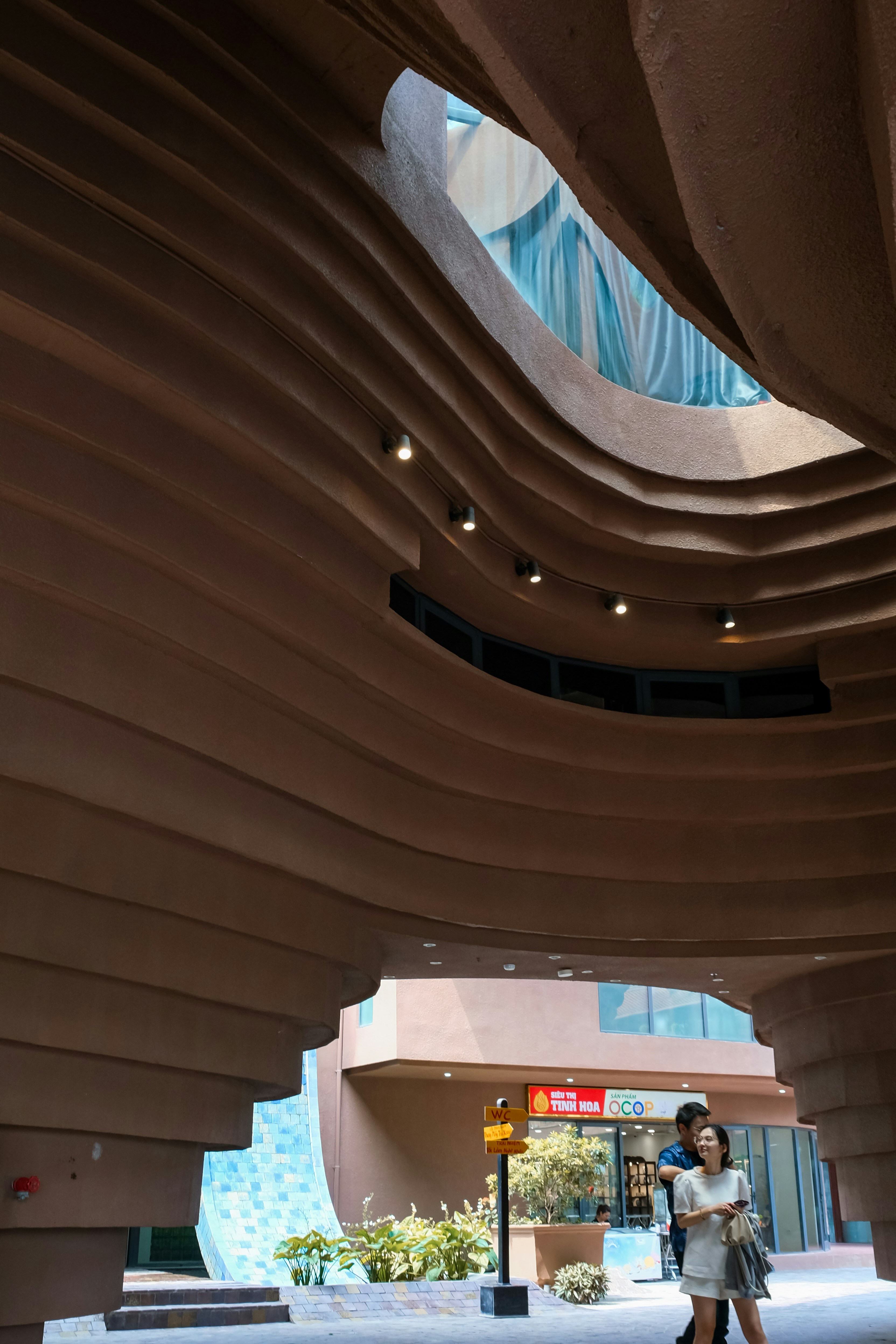 Skyward Whorls: Light Drifts Through a Sculpted Tan Atrium
