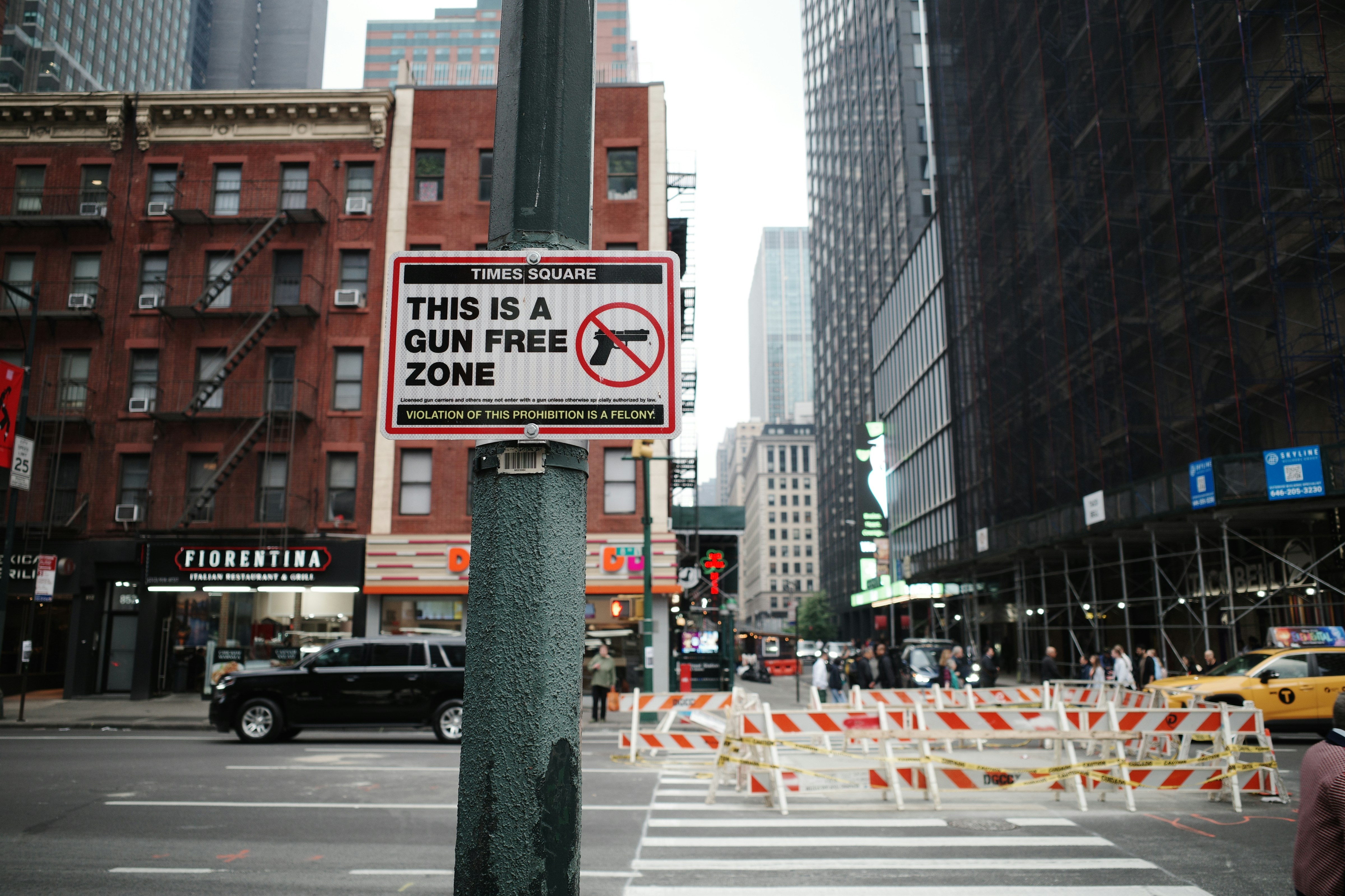 A sign warning of gun free zone on a city street photo – Free Building ...