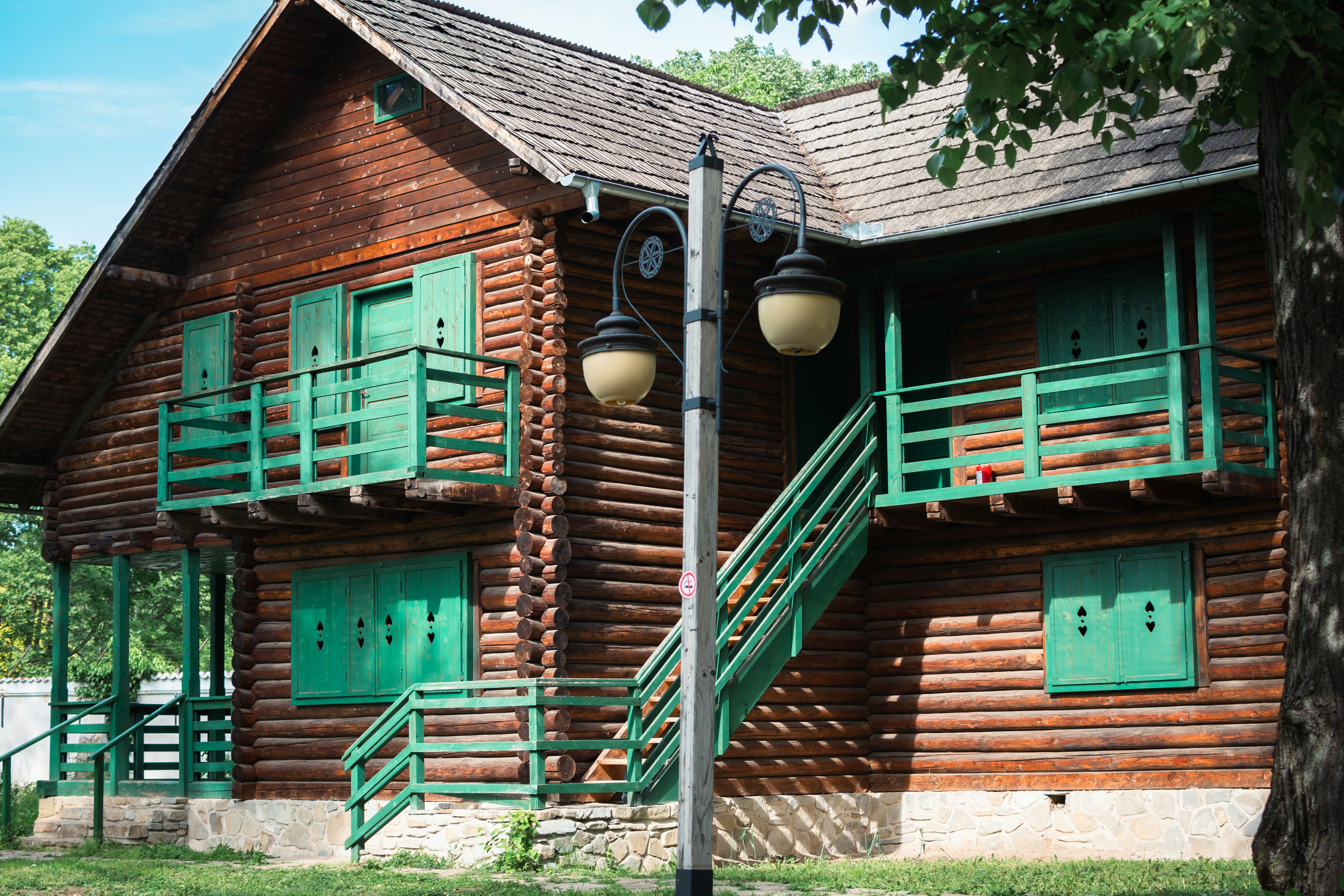 Emerald Balcony Overlook: A Log Cabin Facade with Bright Turquoise Accents