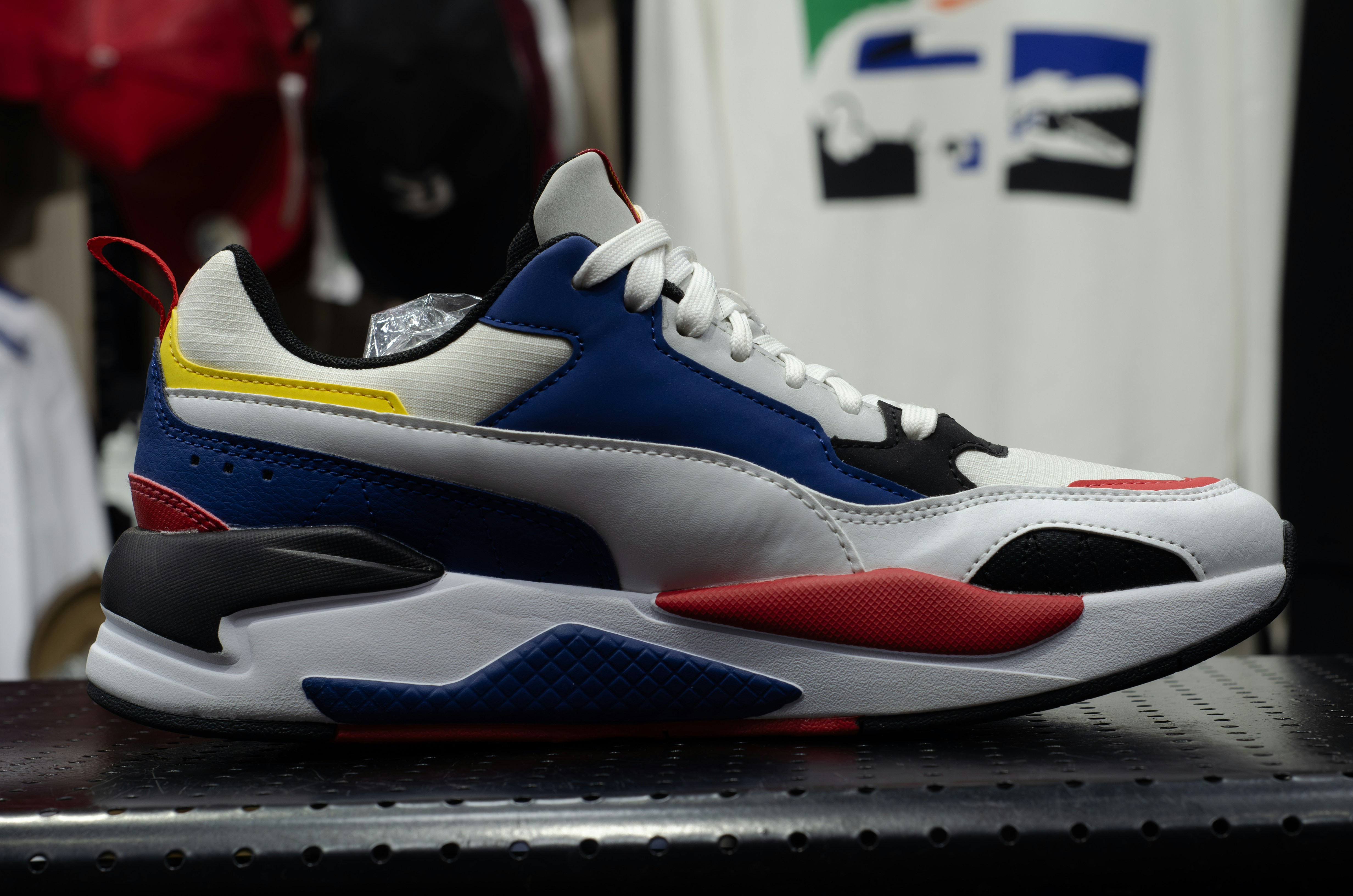 A white and blue sneaker with red, yellow, and blue accents photo ...