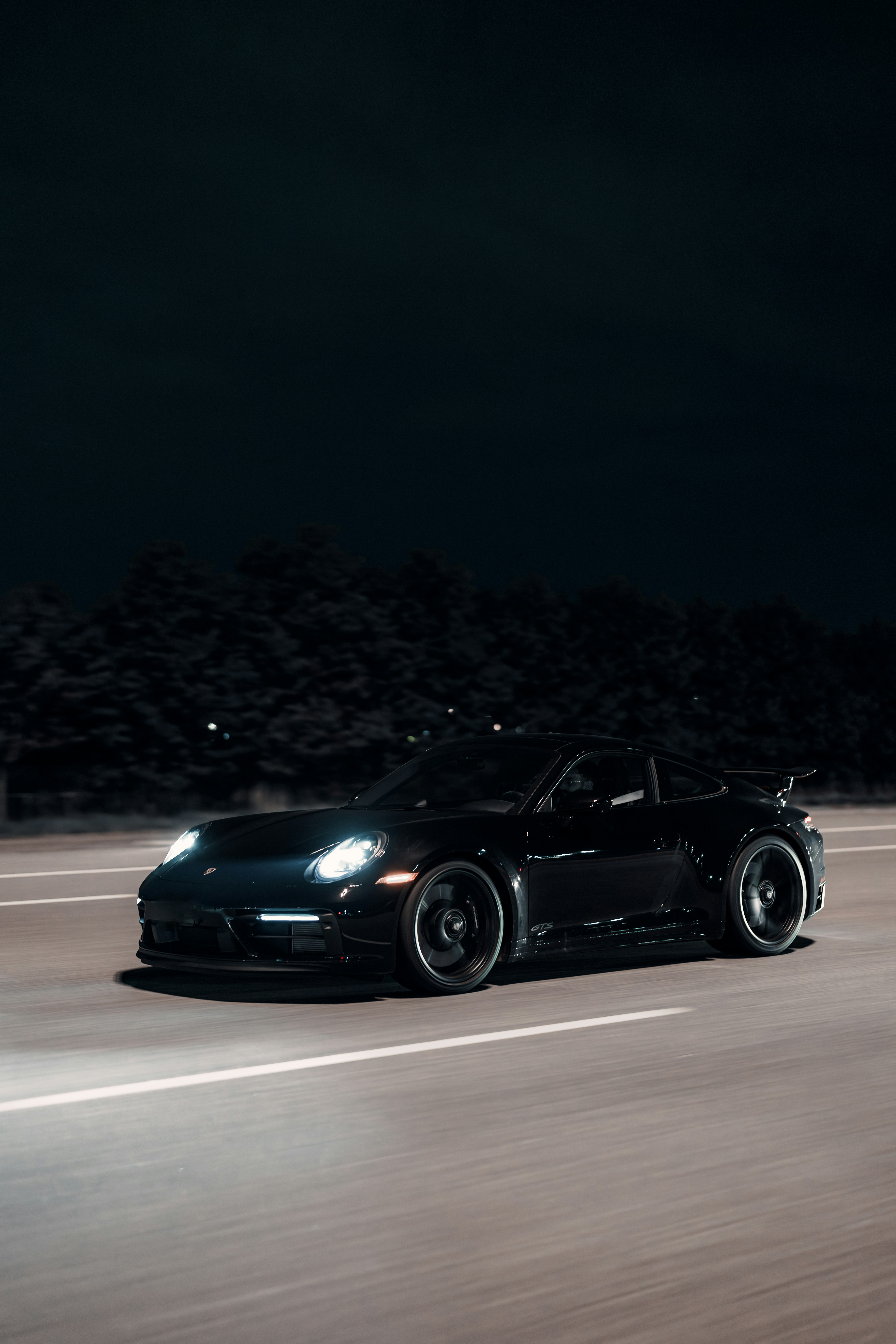 Un'auto sportiva nera che percorre un'autostrada di notte foto ...