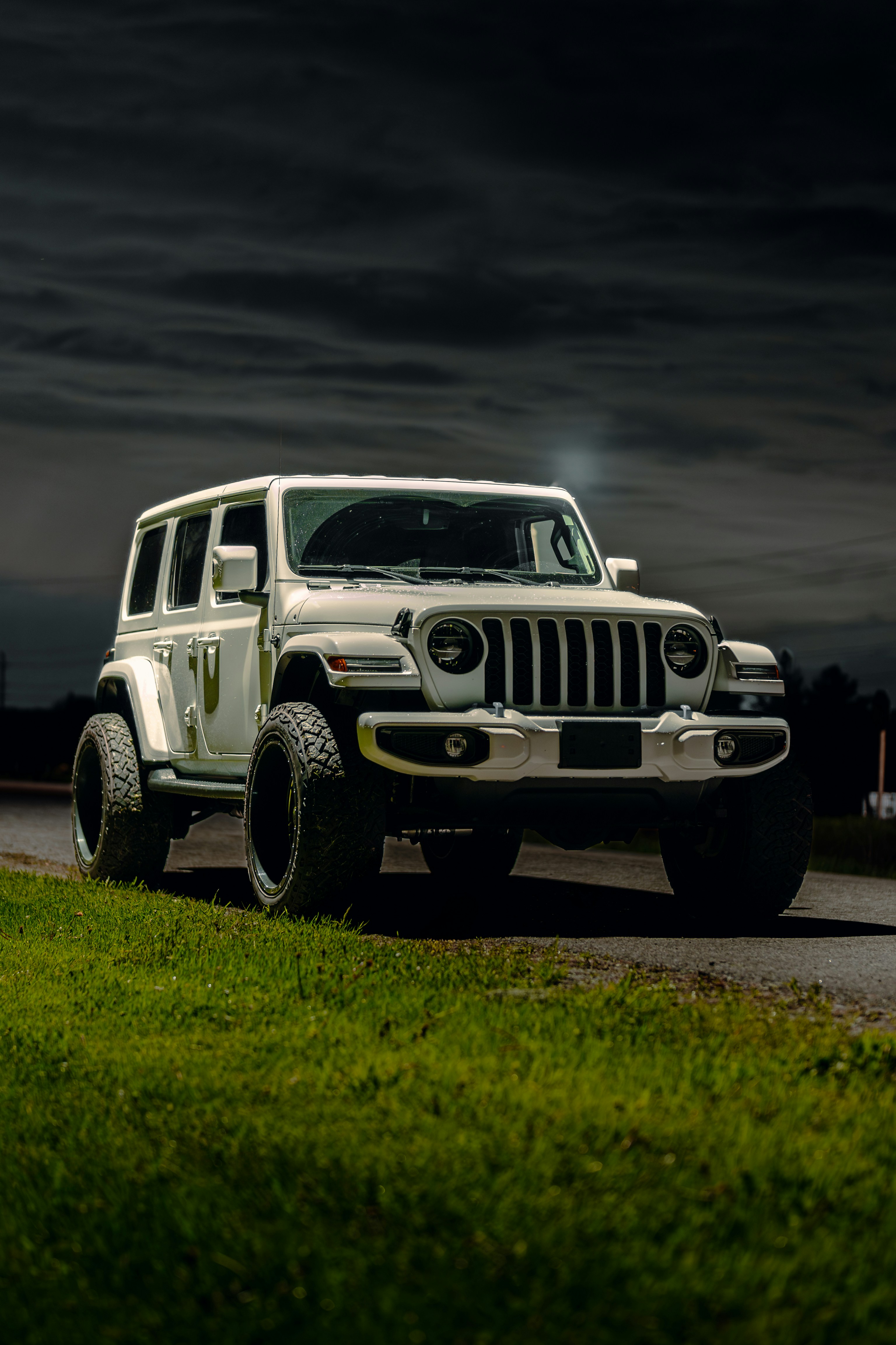 A white jeep driving down a road at night photo – Free Car Image on ...