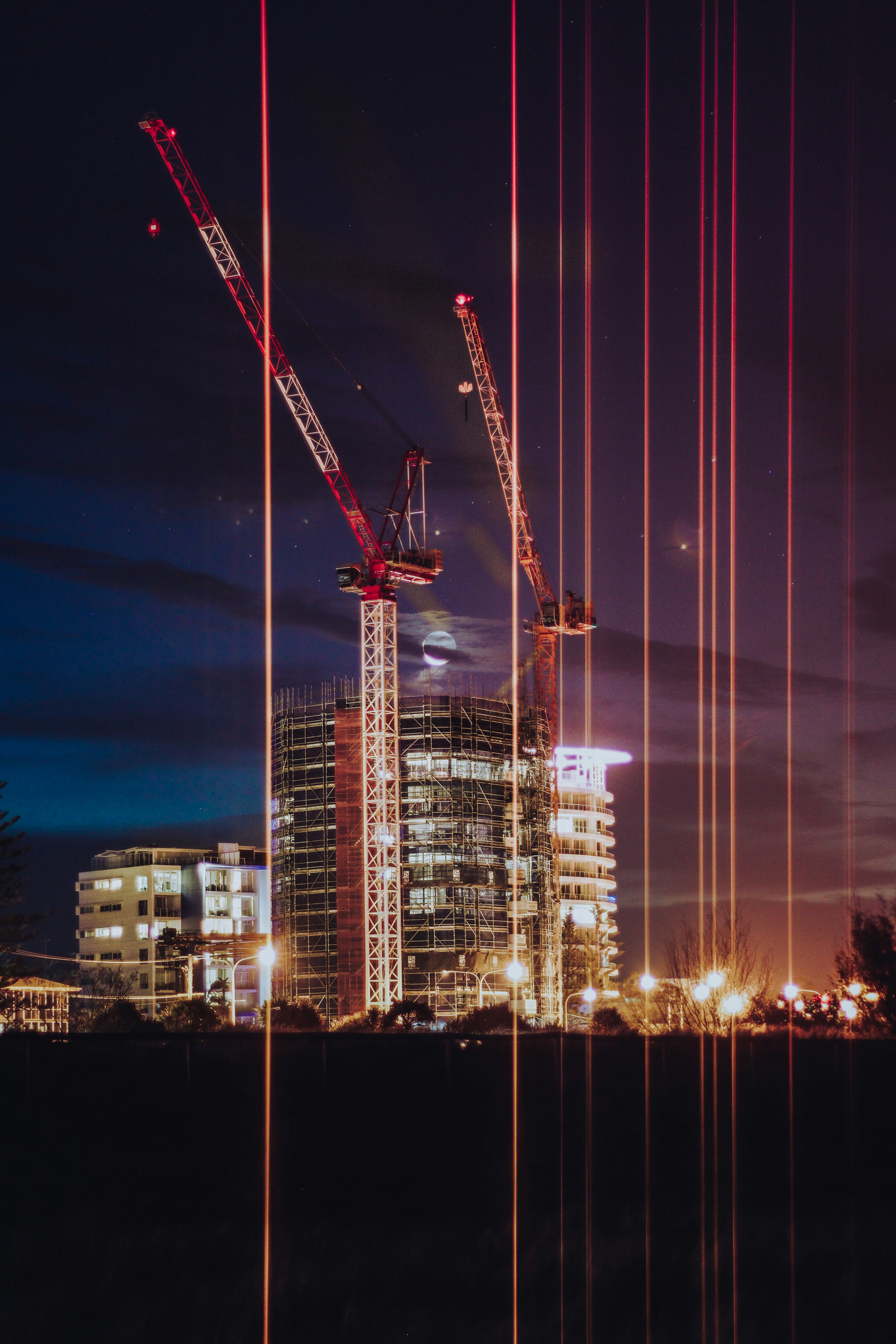 Night Crane Symphony: Red Lines Across a Building Wake