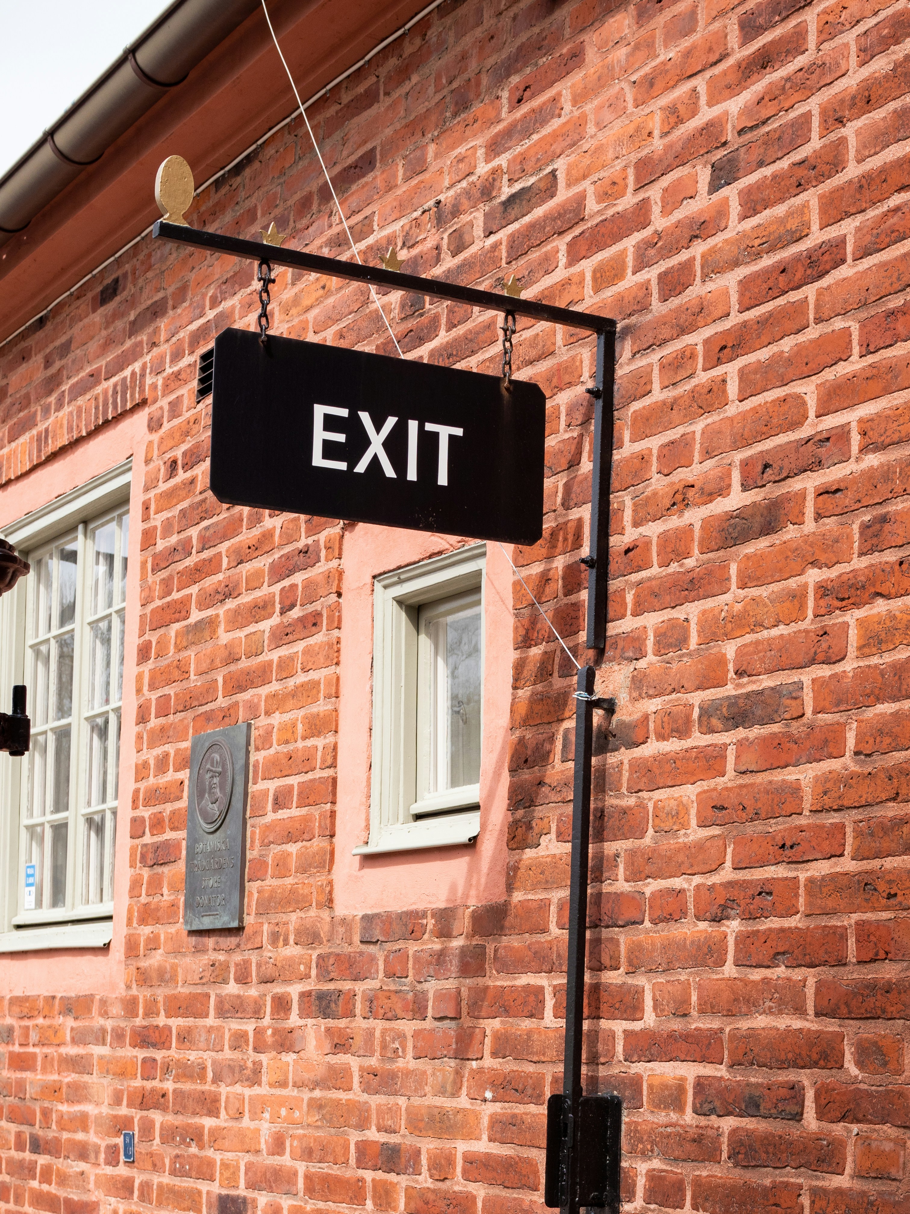 Exit Sign Over Brick Wall: A Quiet Corridor of Red Bricks