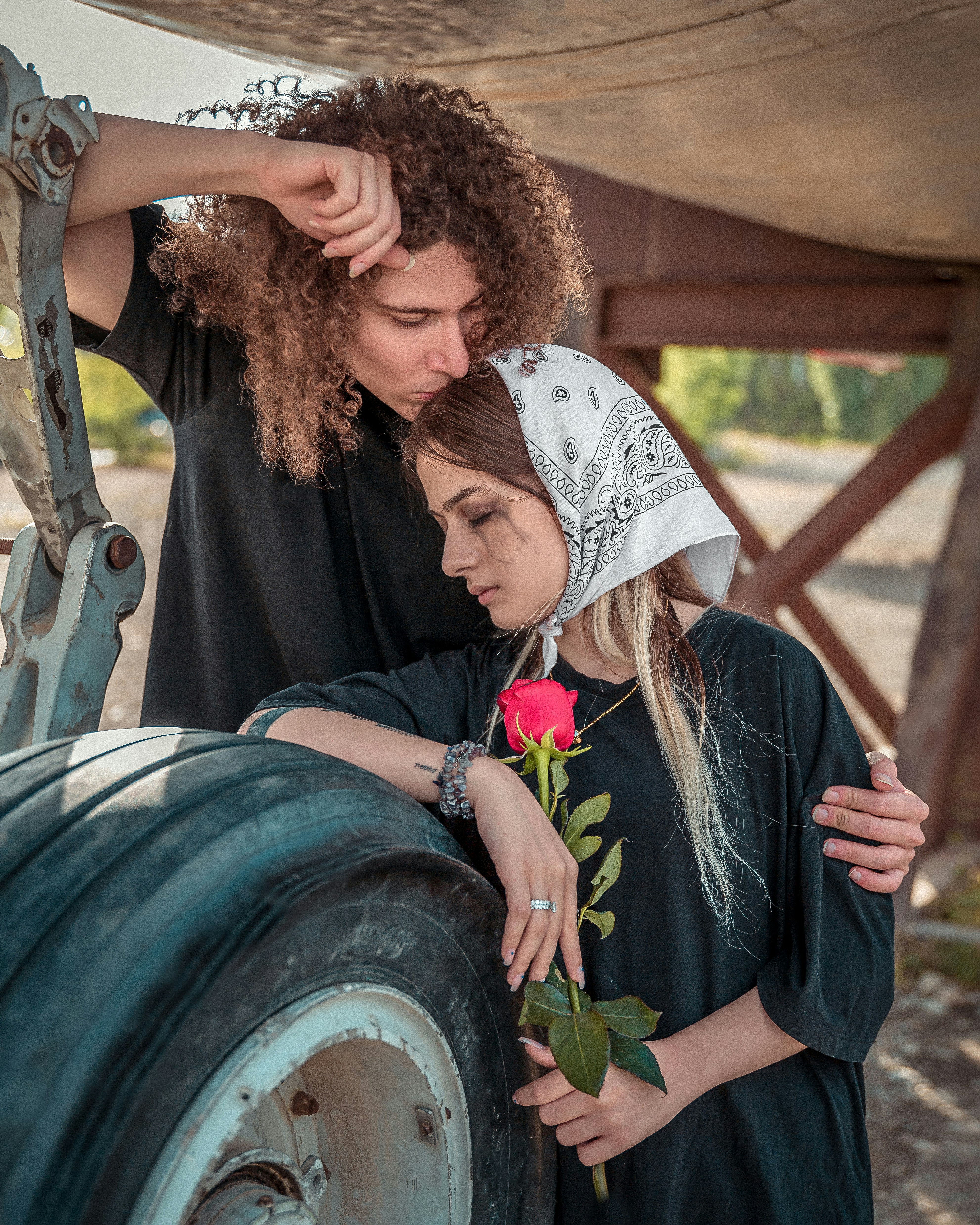 Rose Between Rails: A Tender Moment Under Rusted Iron