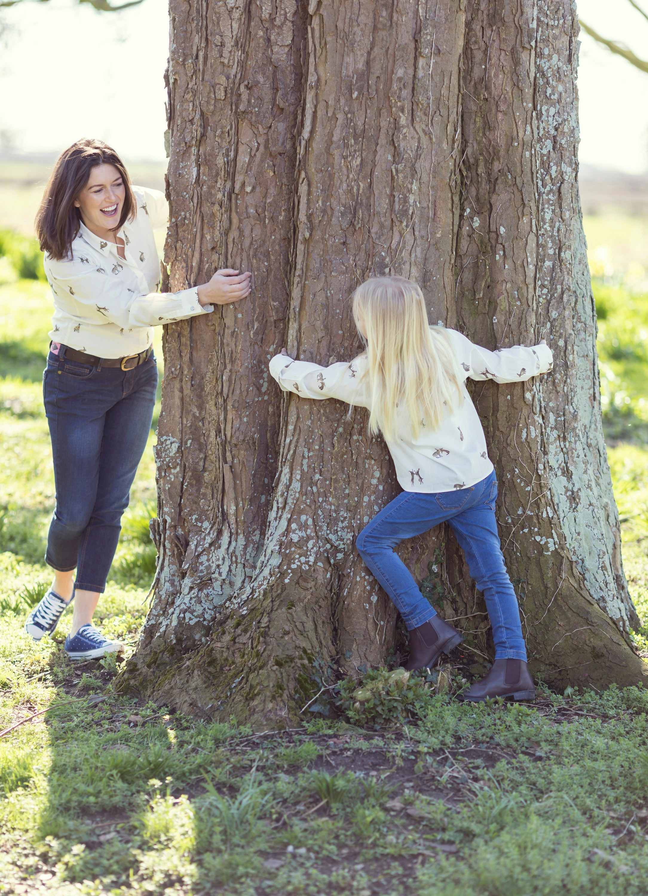 A woman standing next to a tree with a little girl photo – Free Grey ...