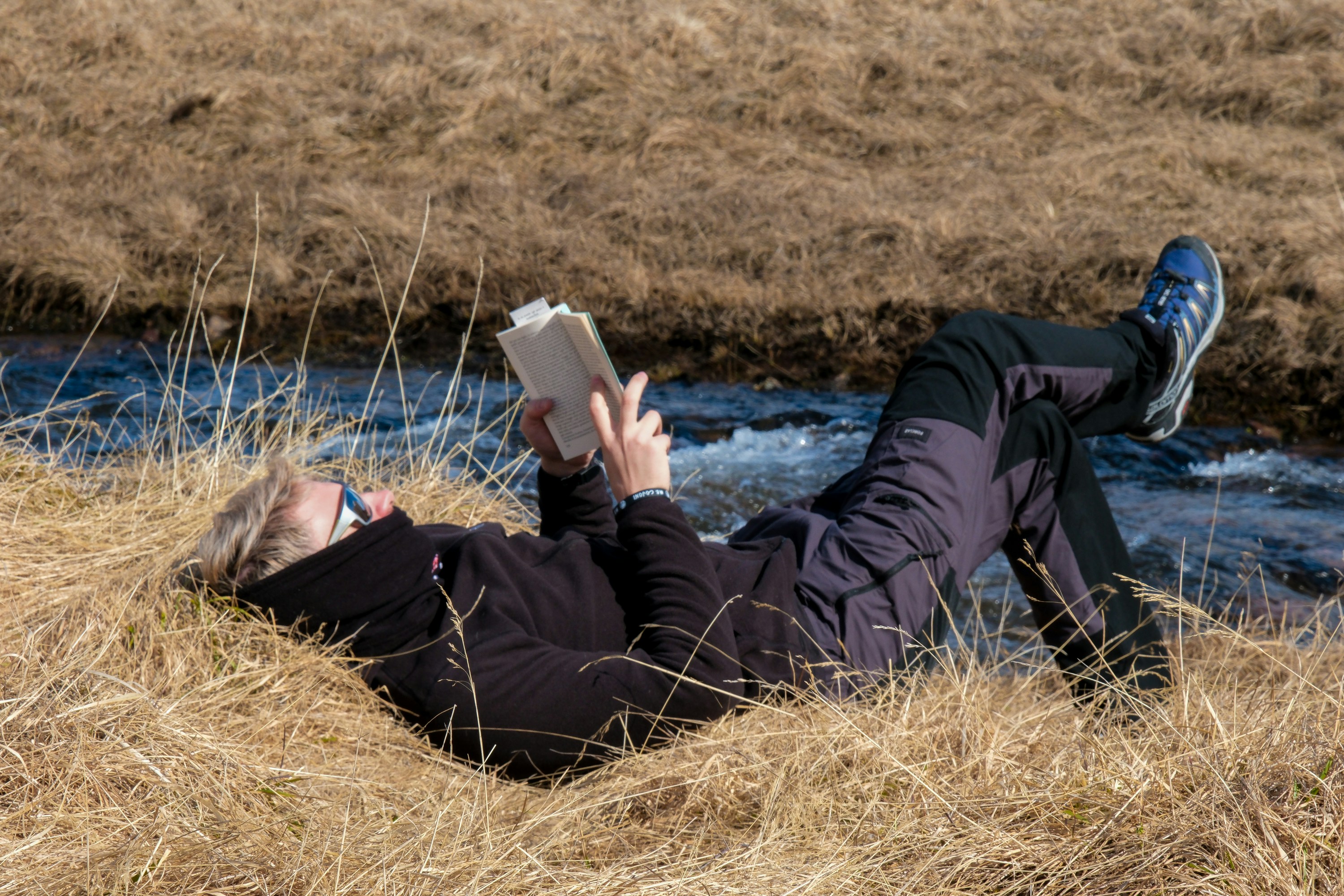 Un hombre tumbado en la hierba leyendo un libro foto – Imagen de Foto ...