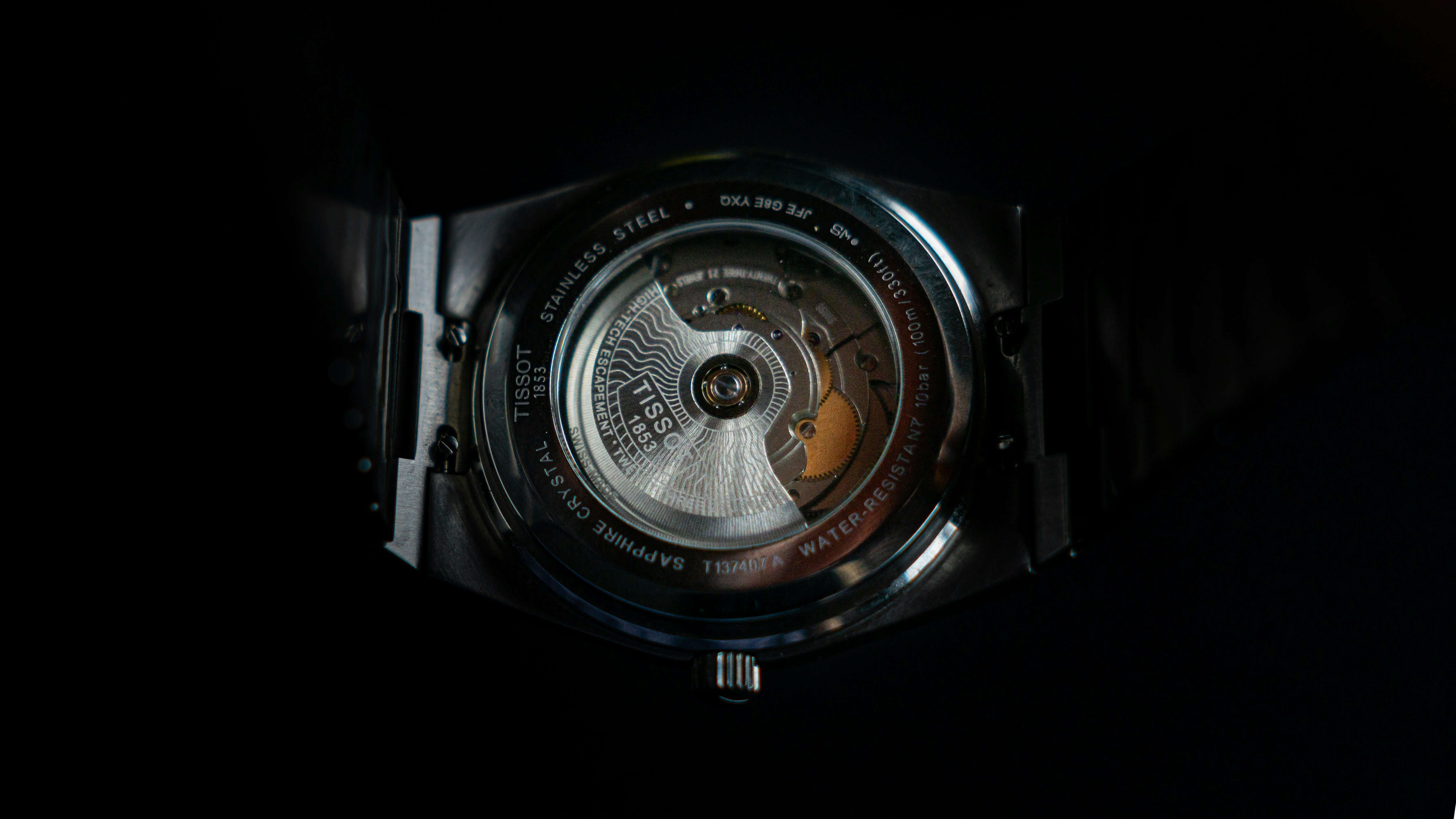 Tissot PRX Powermatic 80 | a close up of a watch in the dark