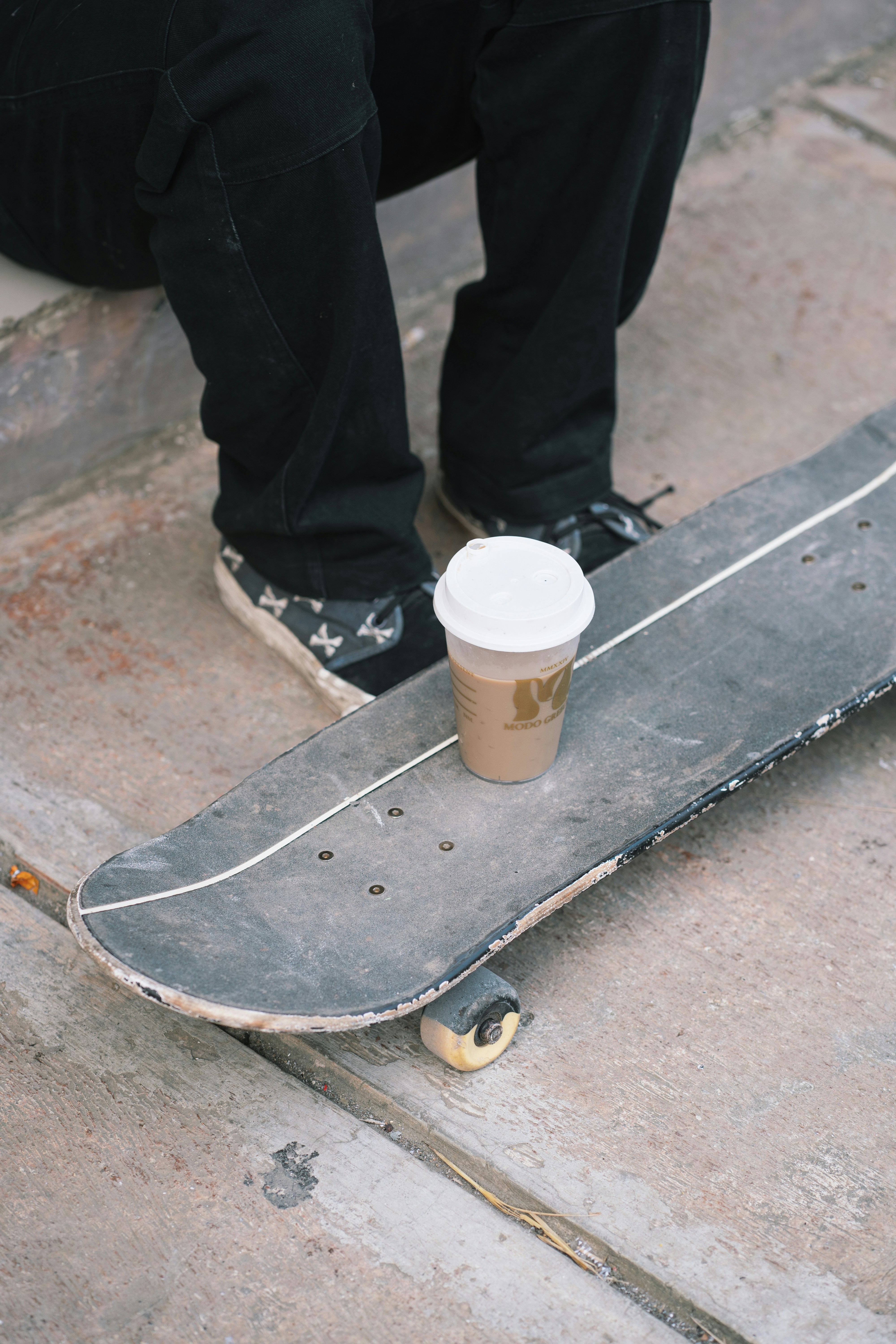 A skateboard with a cup of coffee on top of it photo – Free Skateboard ...