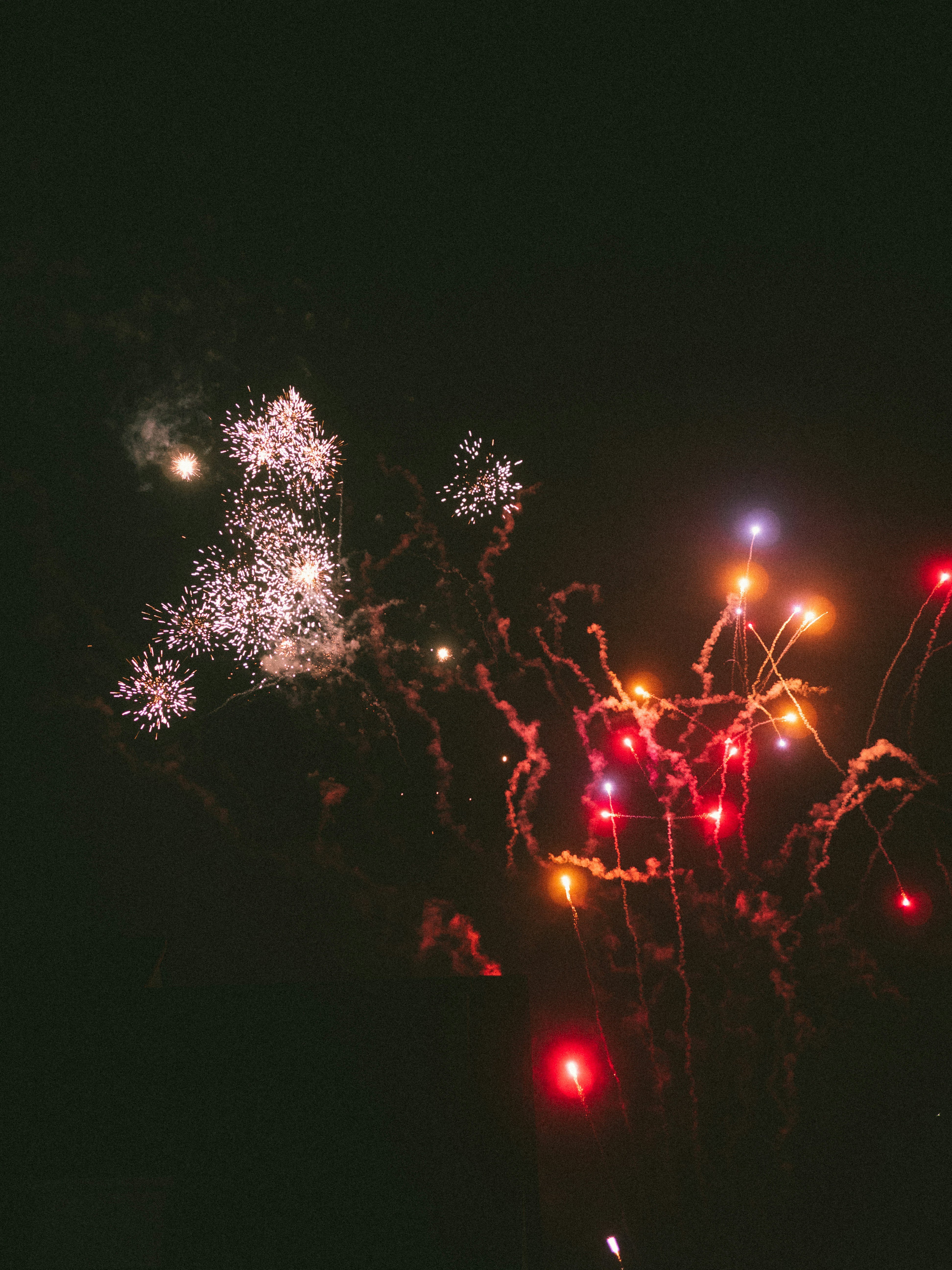 Colorful fireworks bursting against a dark night sky, creating a vibrant display of light and patterns.