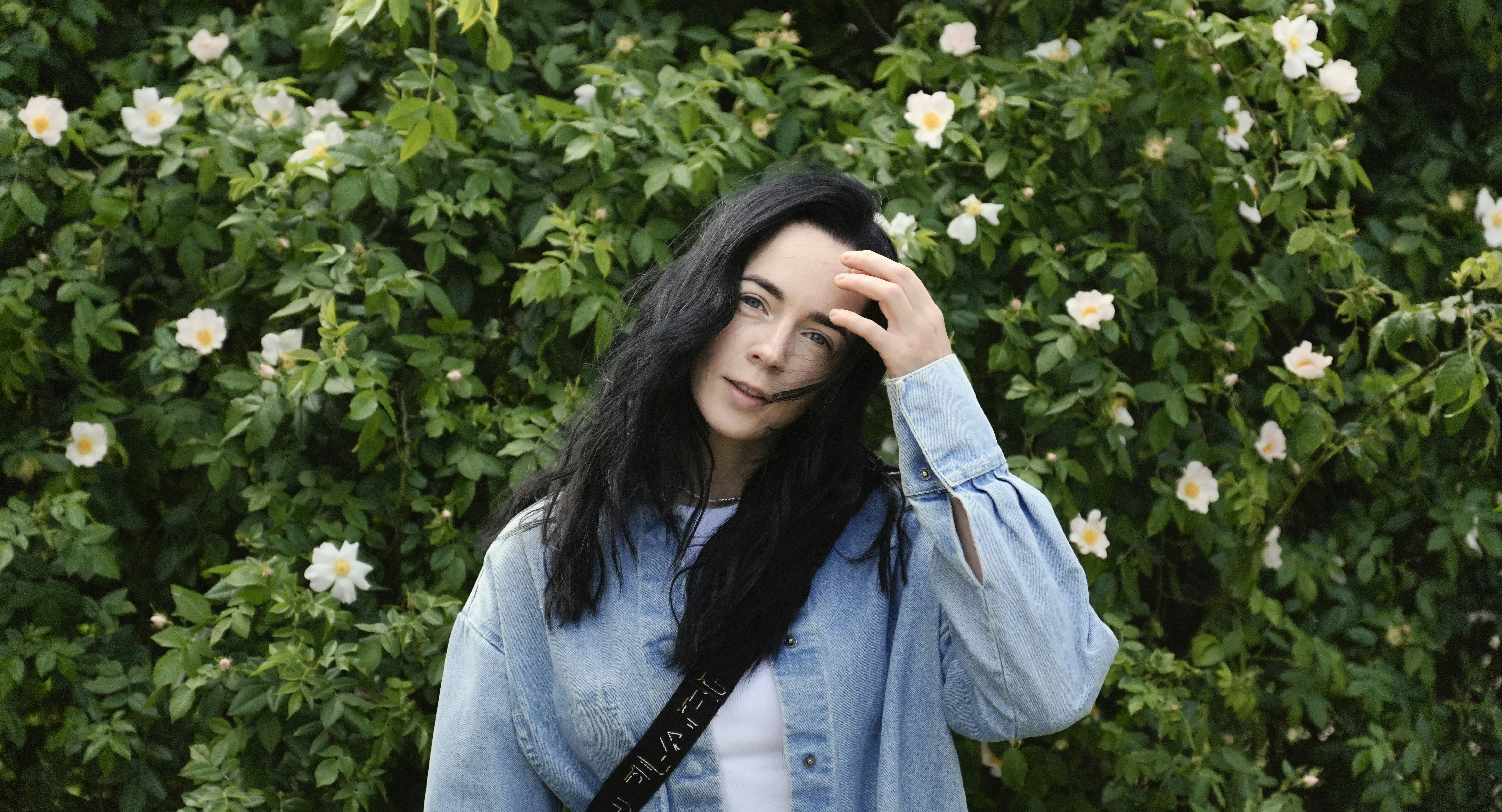 A woman in a white blue T-shirt on a natural green background