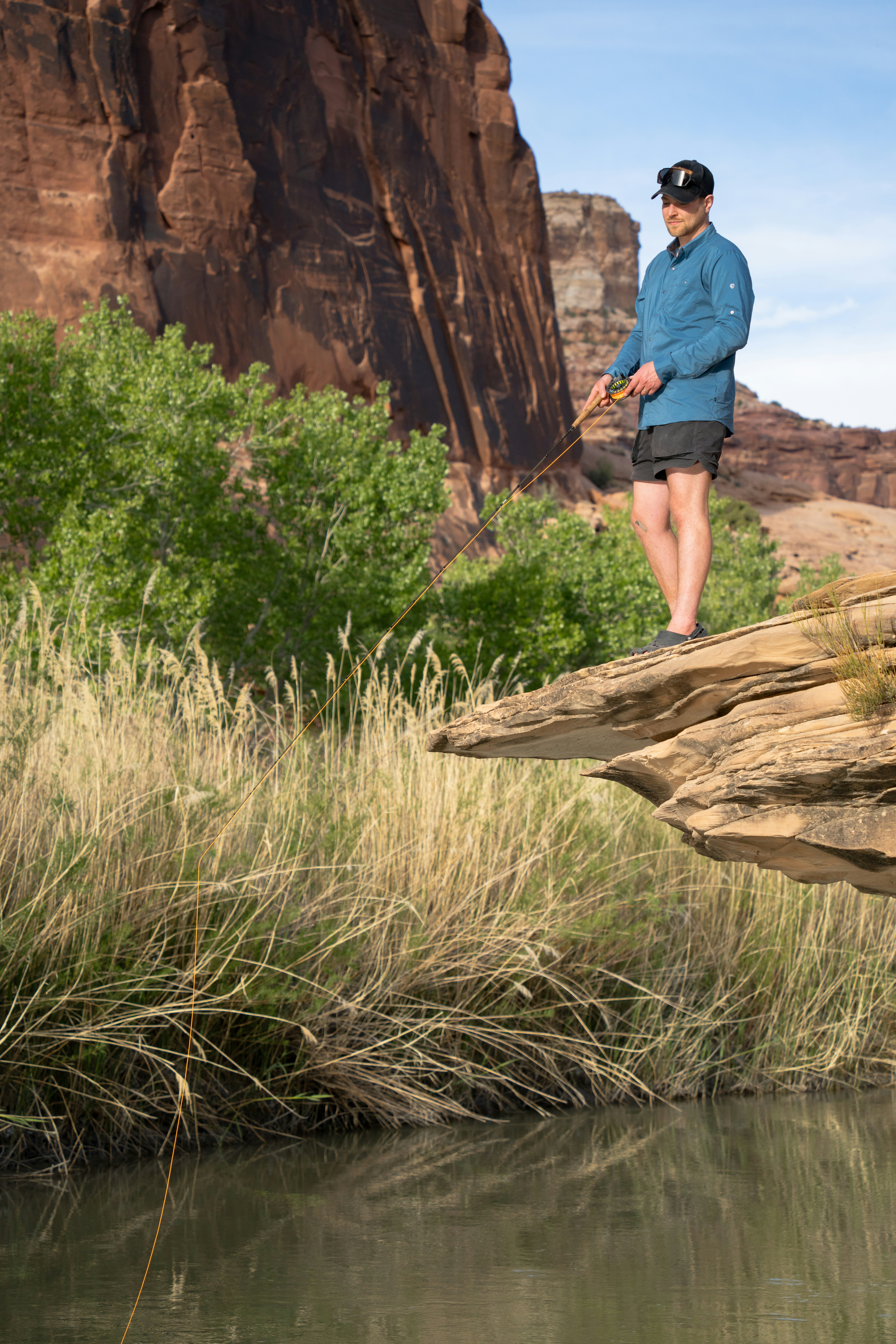 Edgewalker on Sandstone: A Lone Angler Overlooking a Desert Canyon