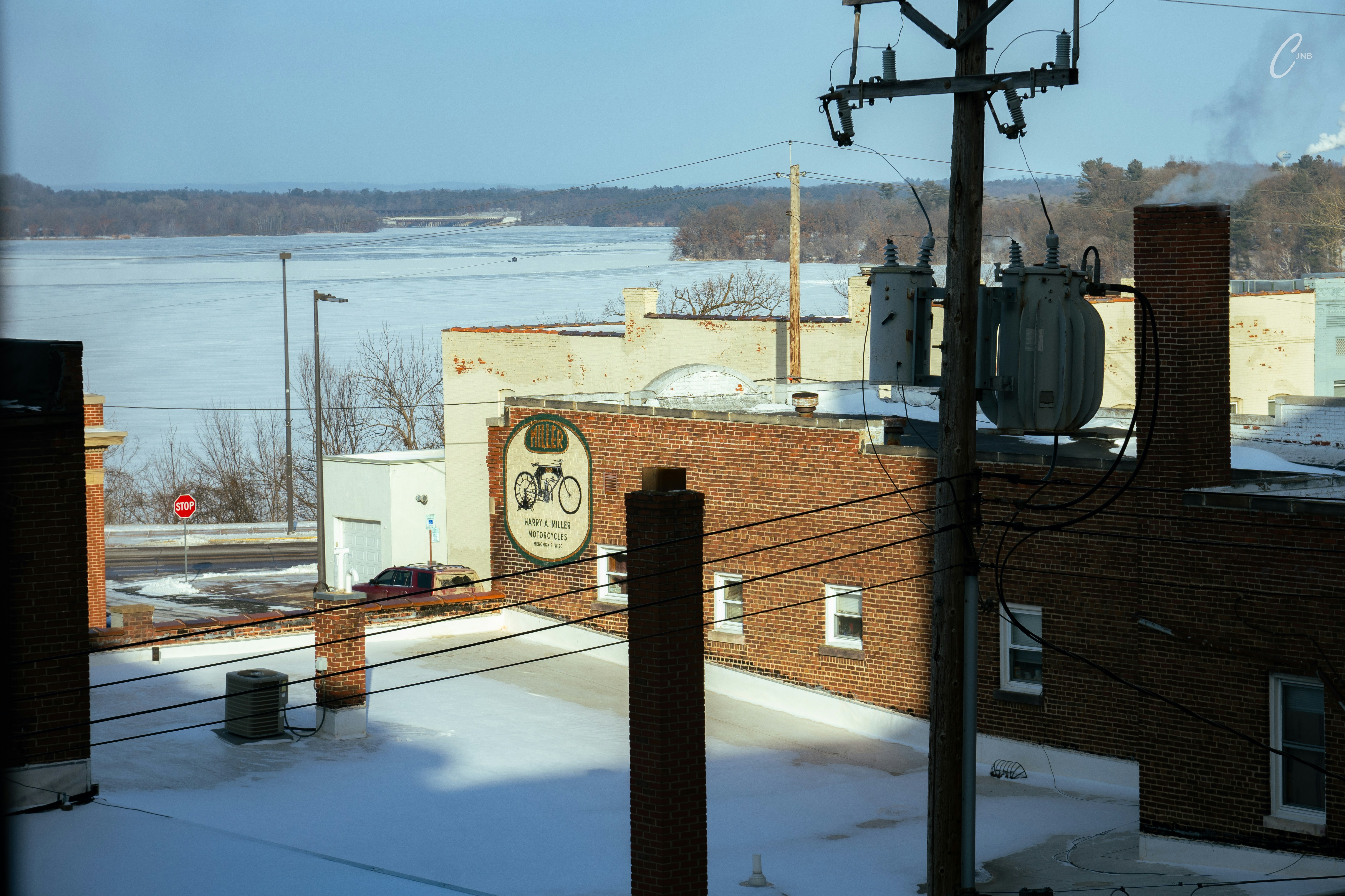 Snowy Rooftops and Distant River Scene