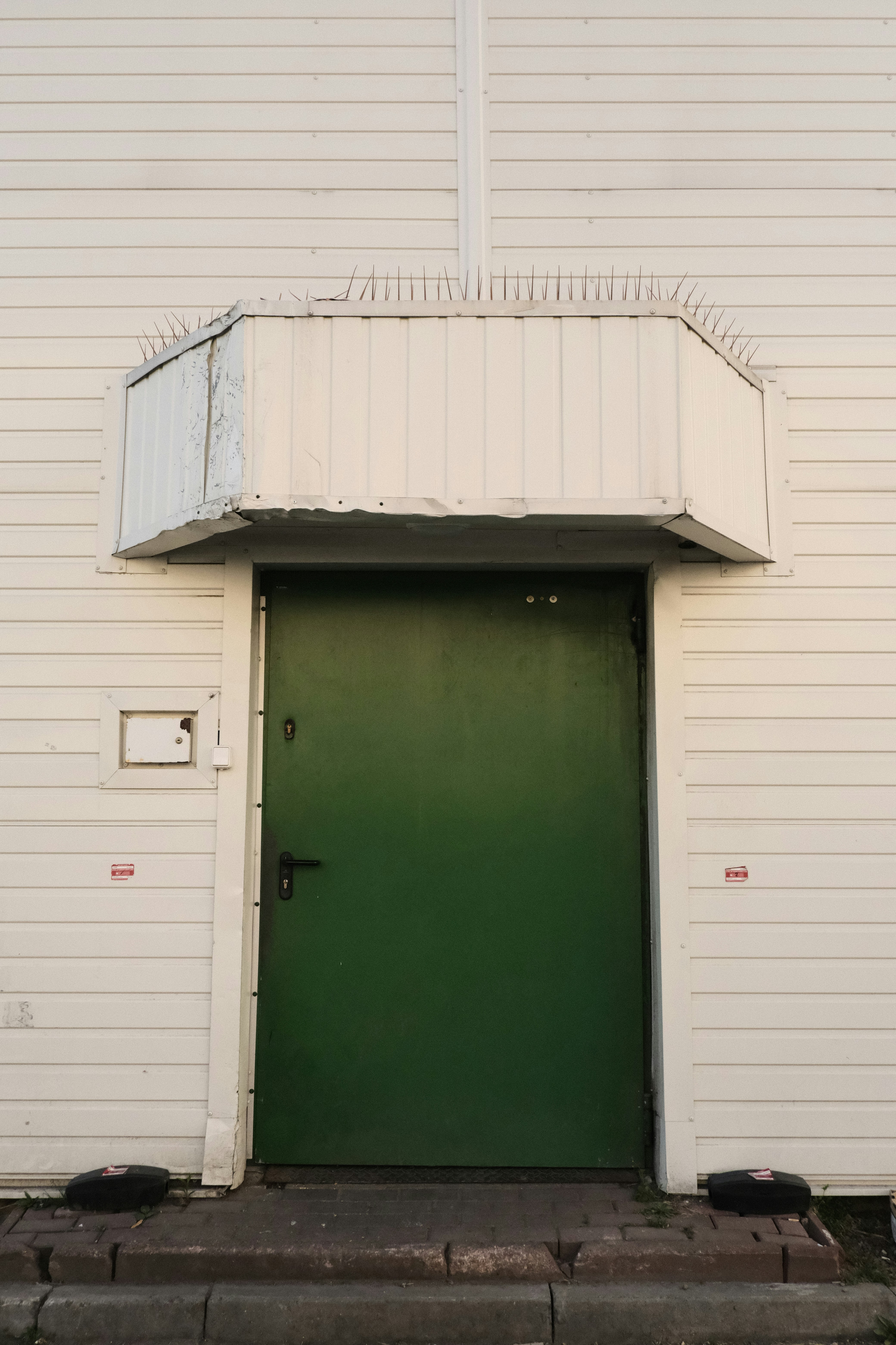 Green doors on a white building, creating a striking contrast and adding a touch of vibrancy to the architectural composition.