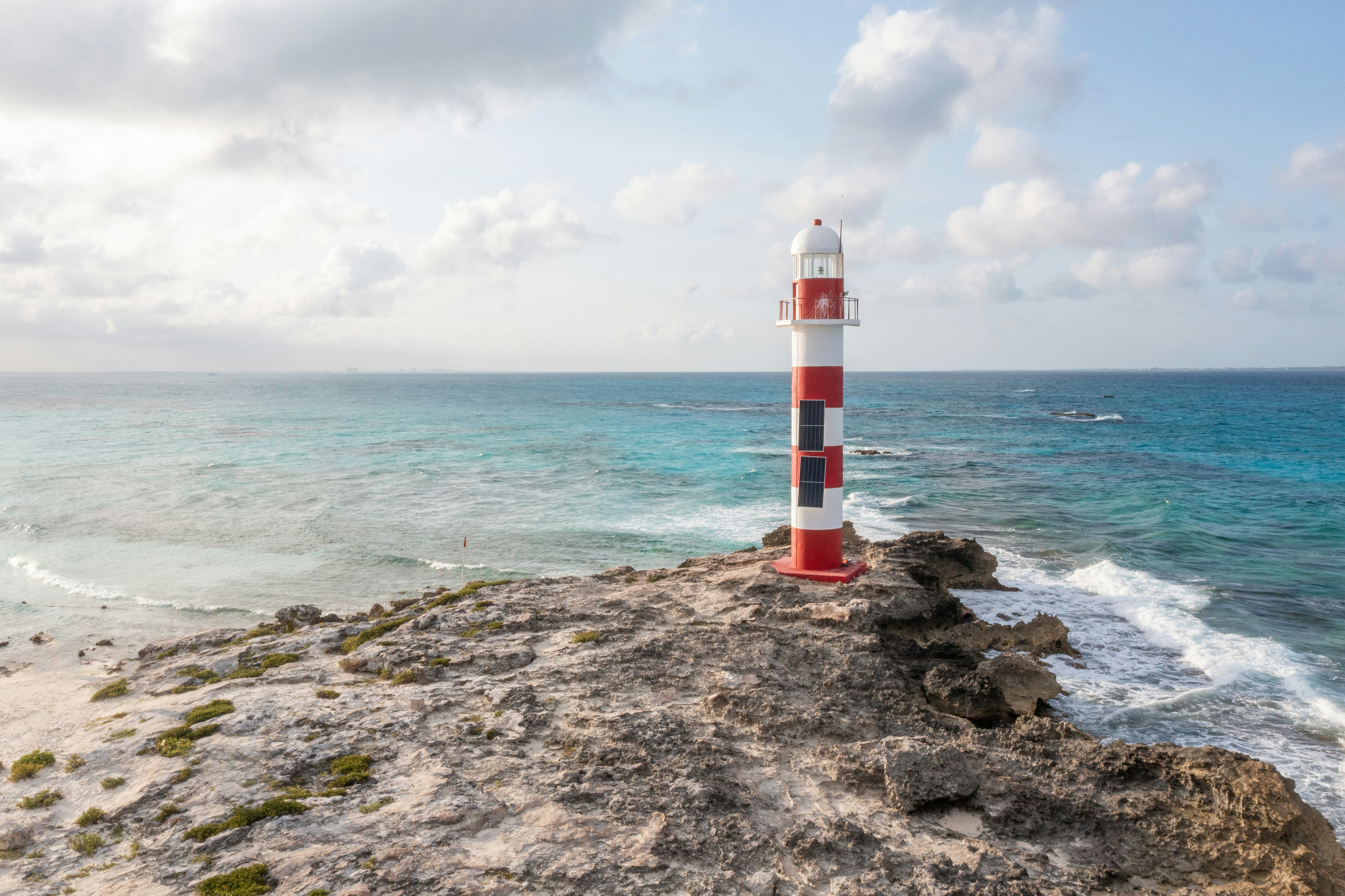 Red Beacon on the Edge: A Seaside Sentinel Over Turquoise Waters