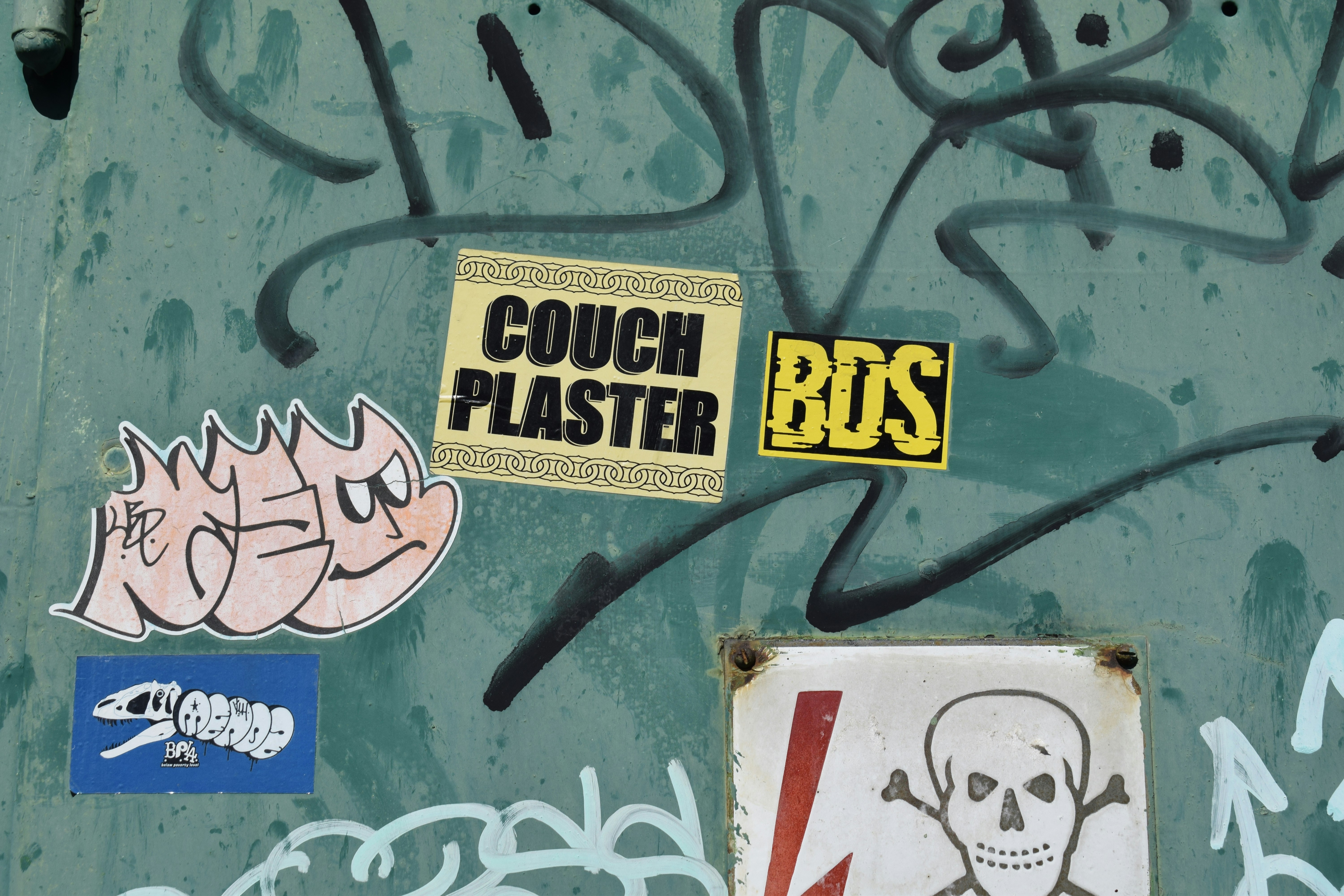 A bunch of stickers on the side of a wall photo – Free Art Image on ...