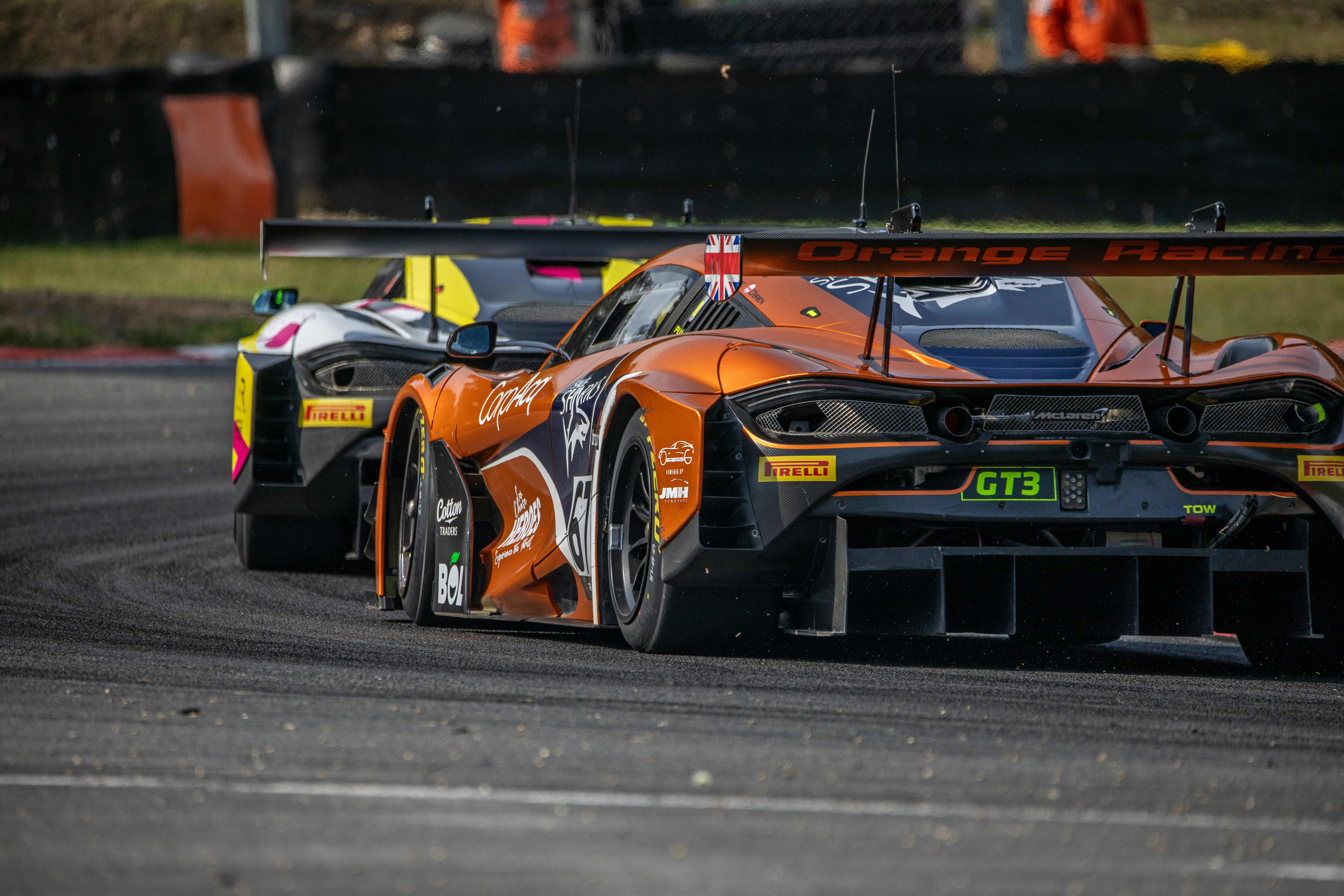 An orange race car driving on a race track photo – Free Pirelli tires ...