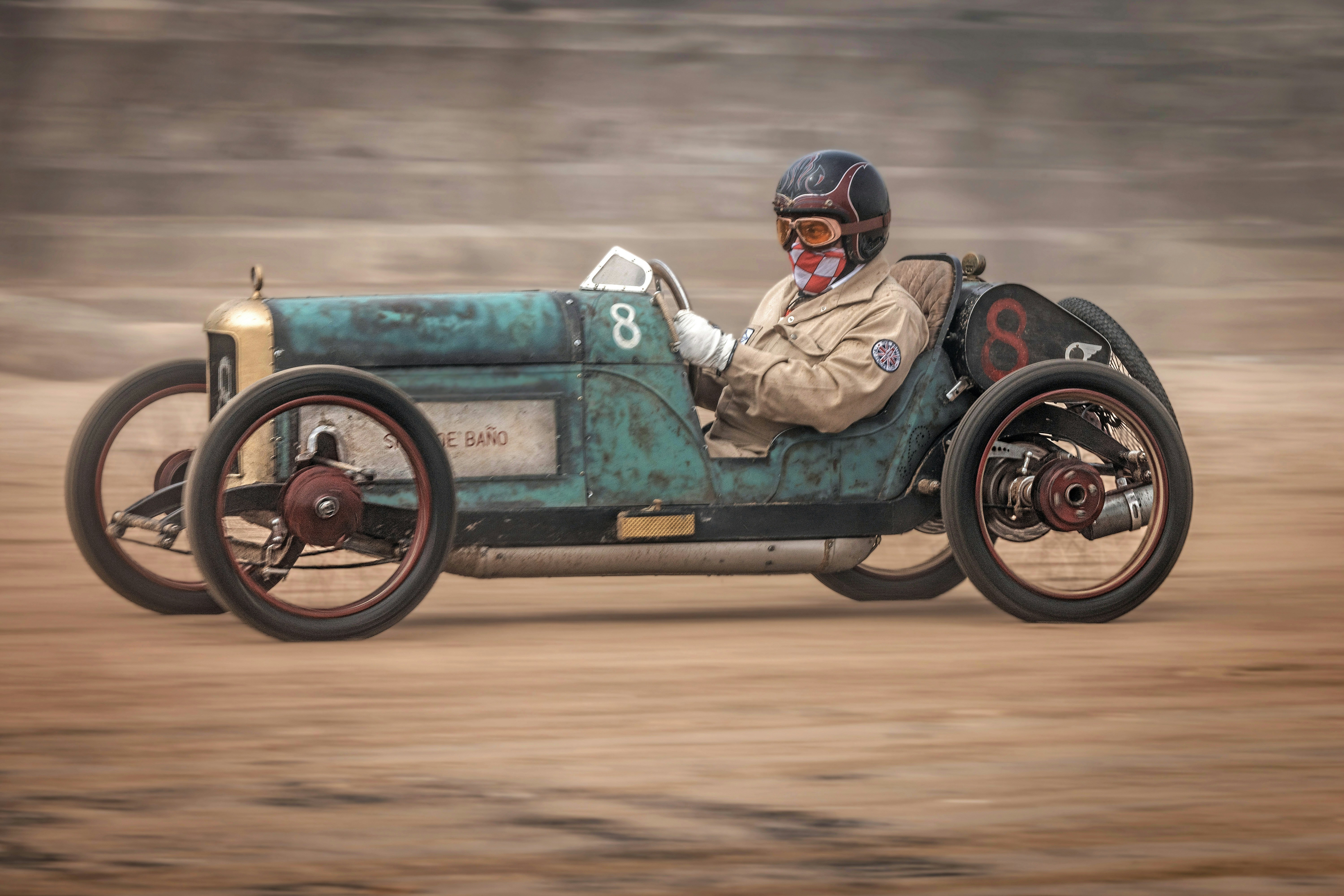 Dusty Sprint: A Vintage Green Open-Cockpit Racer in Action